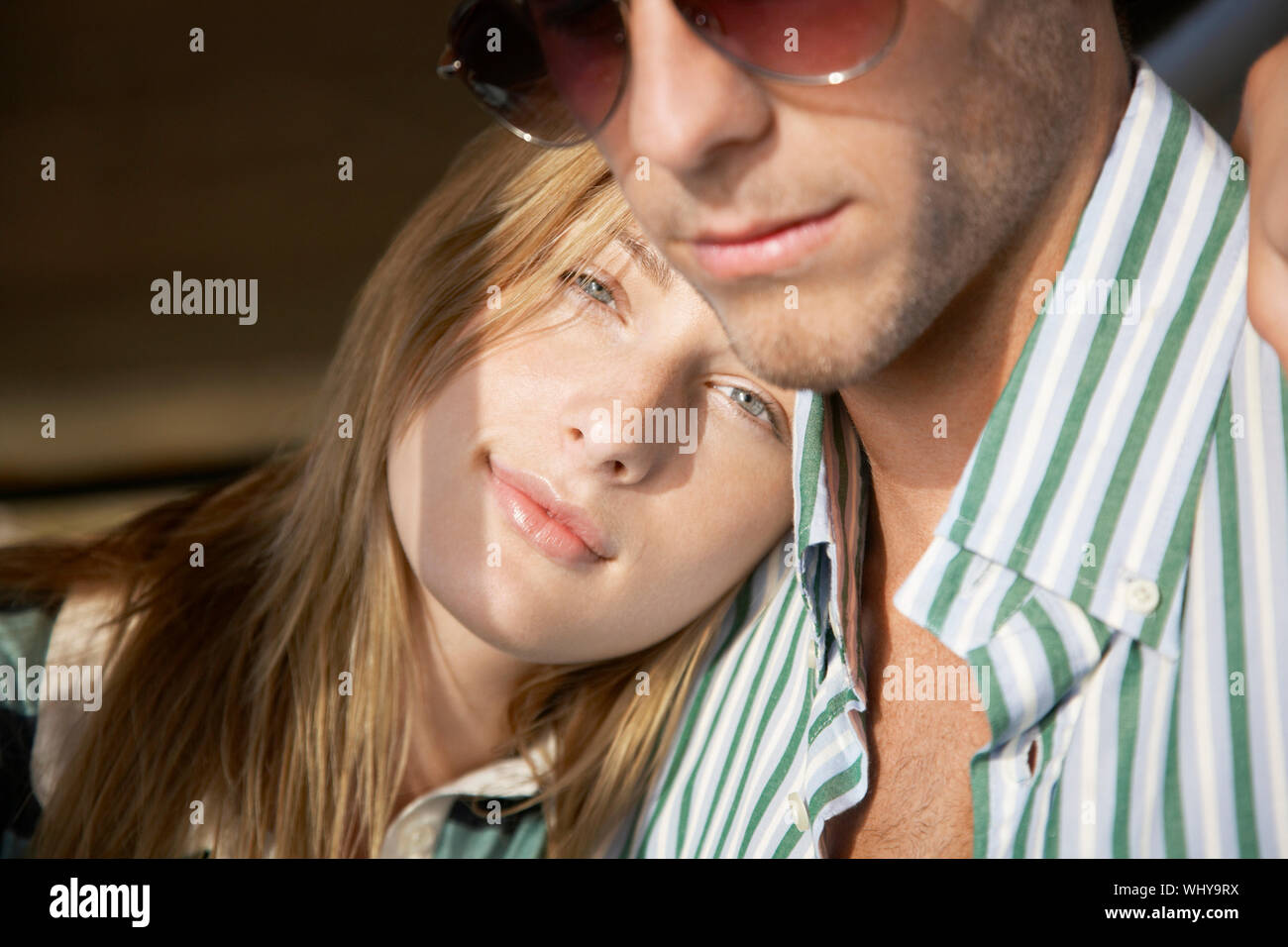 Beautiful young woman resting head on boyfriend's shoulder during road ...