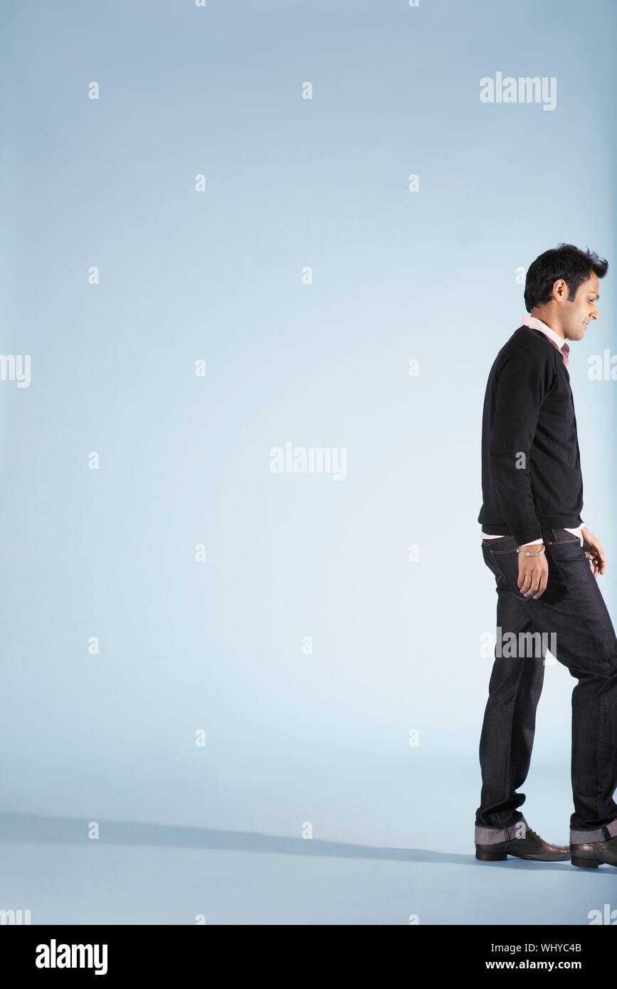 Side view of young man walking isolated on blue background Stock Photo ...