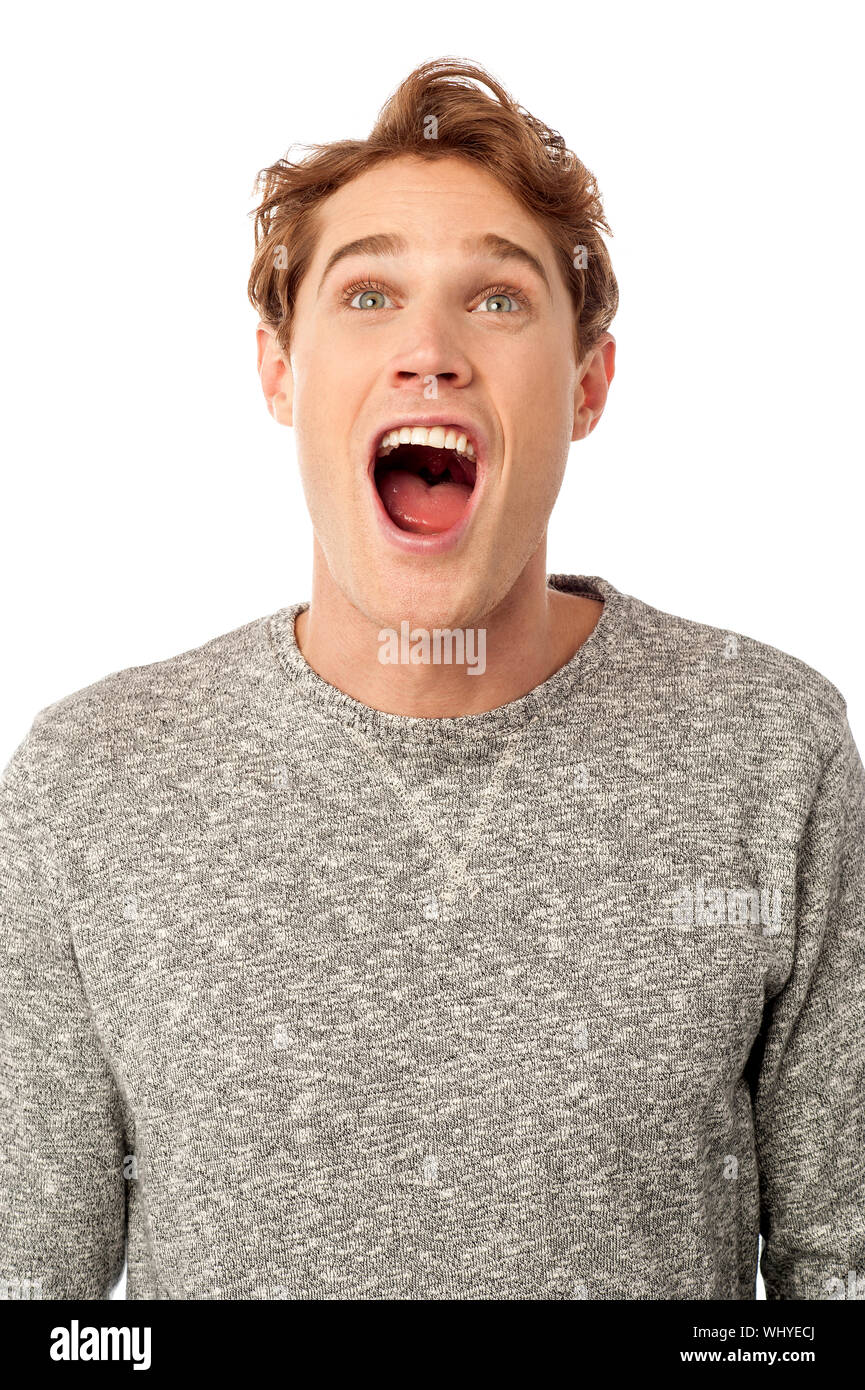 Shocked young excited guy over white Stock Photo - Alamy