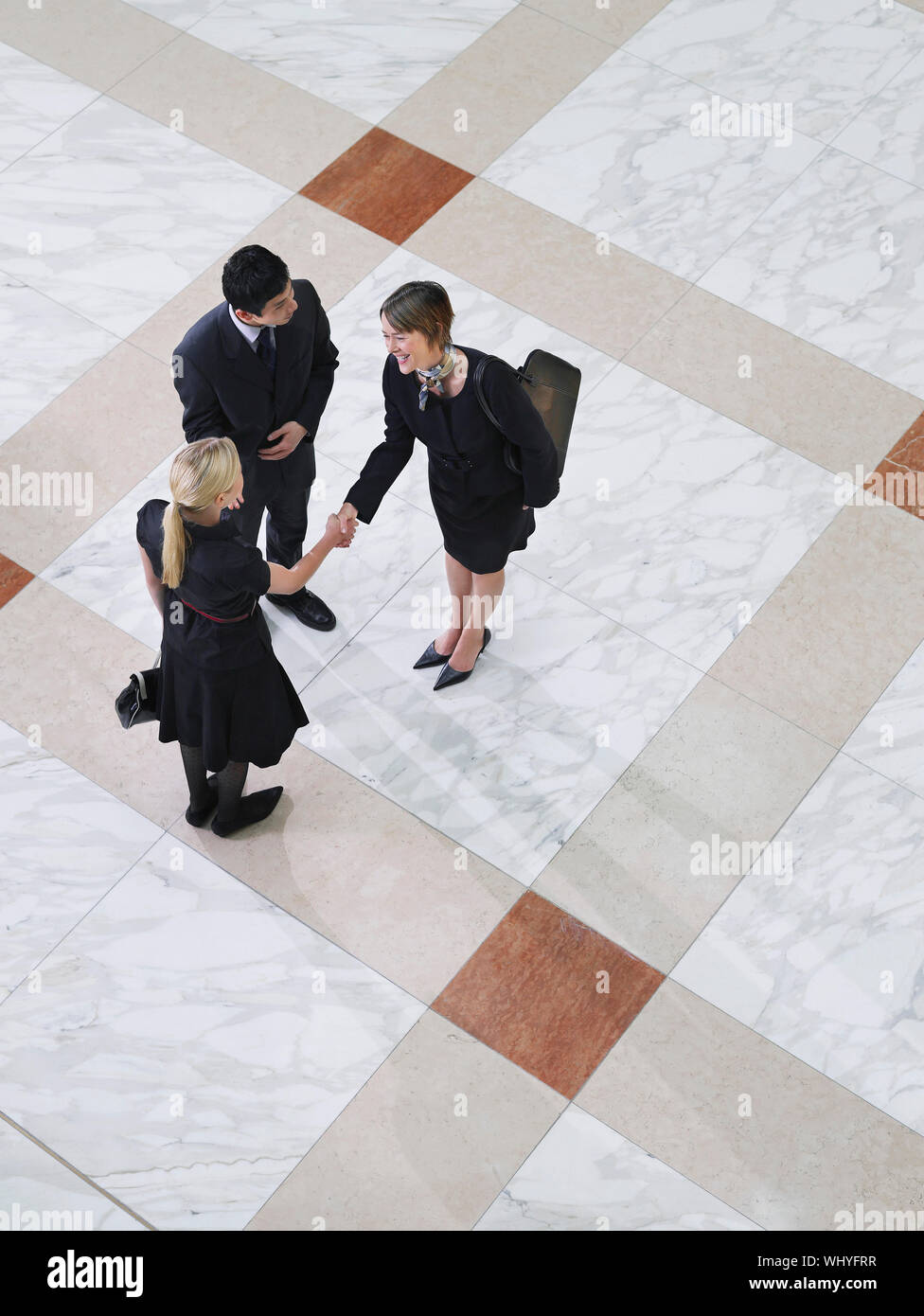 Elevated view of business people shaking hands on tiled floor Stock ...