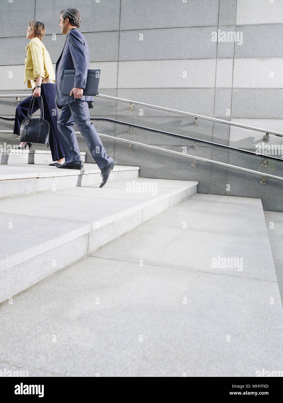 Side view of two business people walking up steps outdoors Stock Photo ...