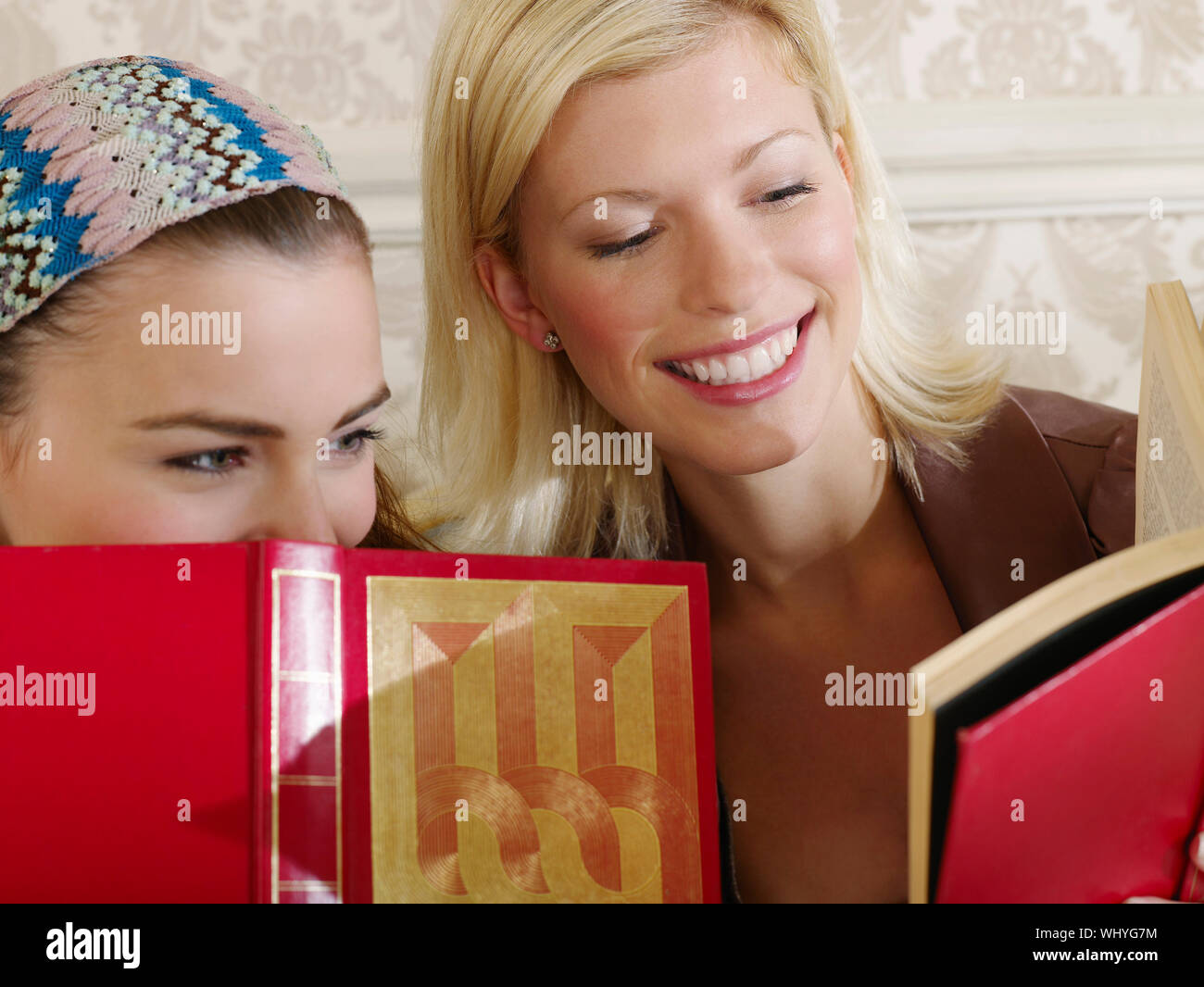 Closeup of two cheerful young women with books Stock Photo - Alamy