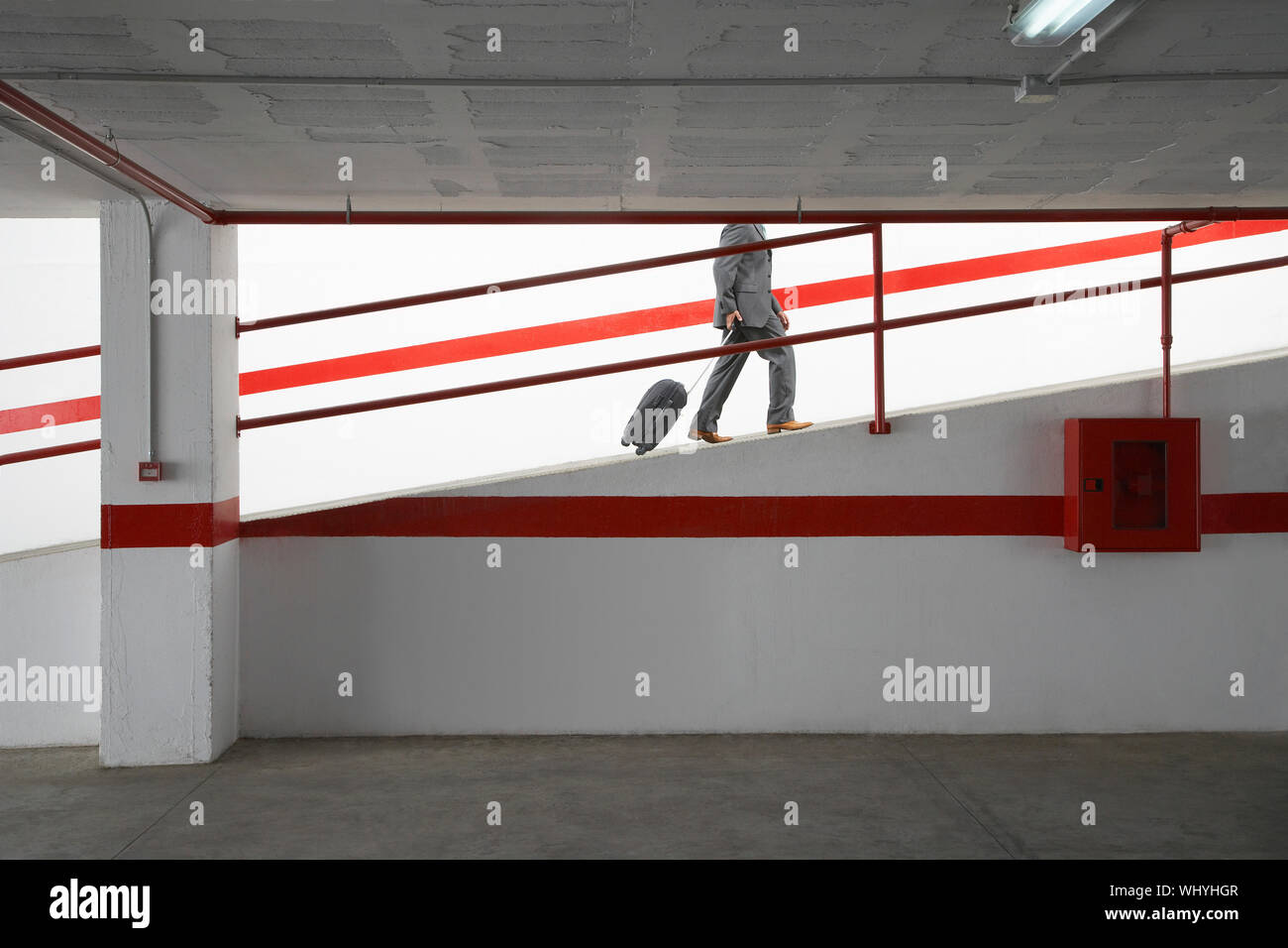 Side view low section of a businessman walking up ramp in parking ...