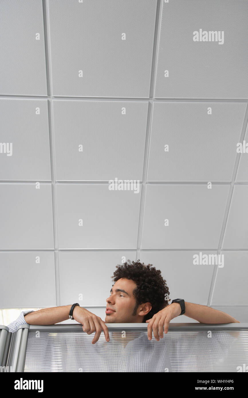 Young male office worker peering over cubicle wall in the office Stock ...