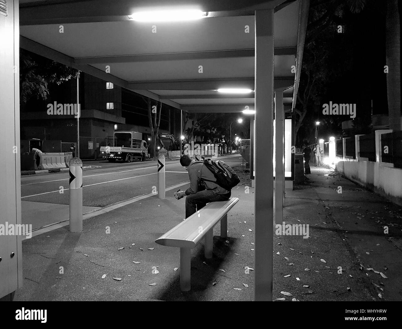 Sitting on bus stop bench hi-res stock photography and images - Alamy