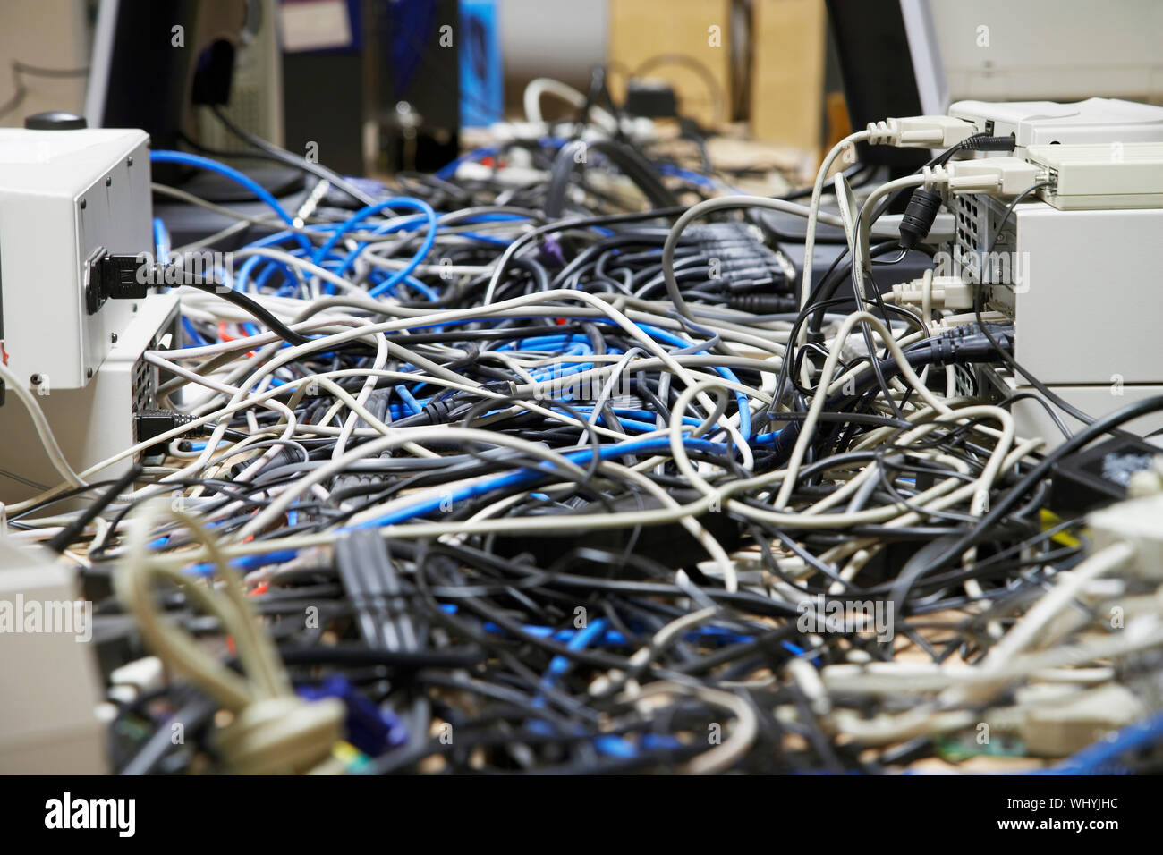 Closeup of messed wires connecting computers and printers in office ...