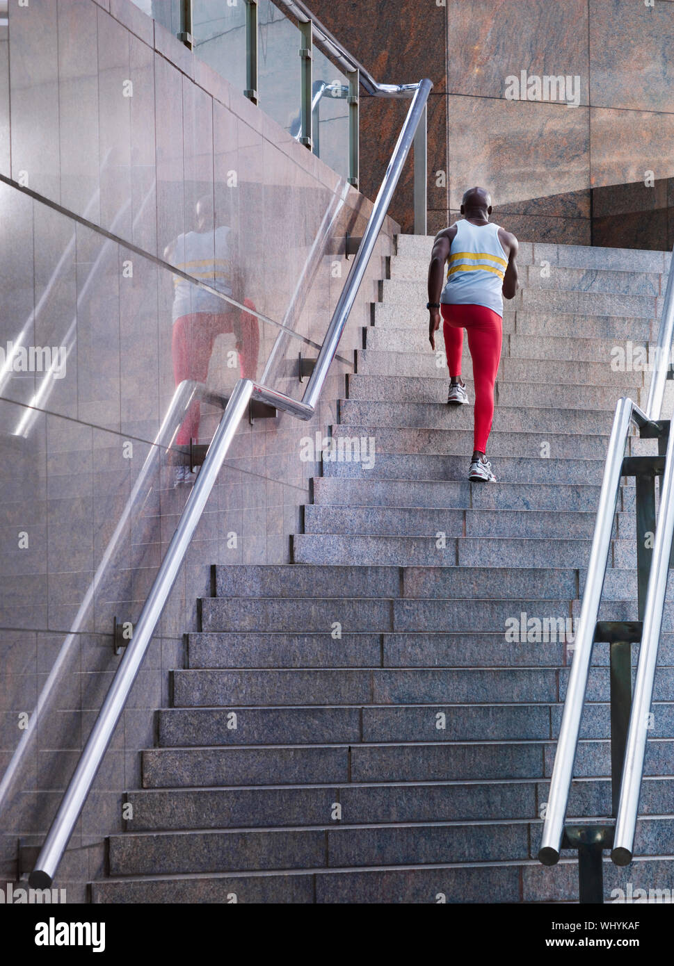 Rear view of a male athlete running up staircase outside building Stock ...
