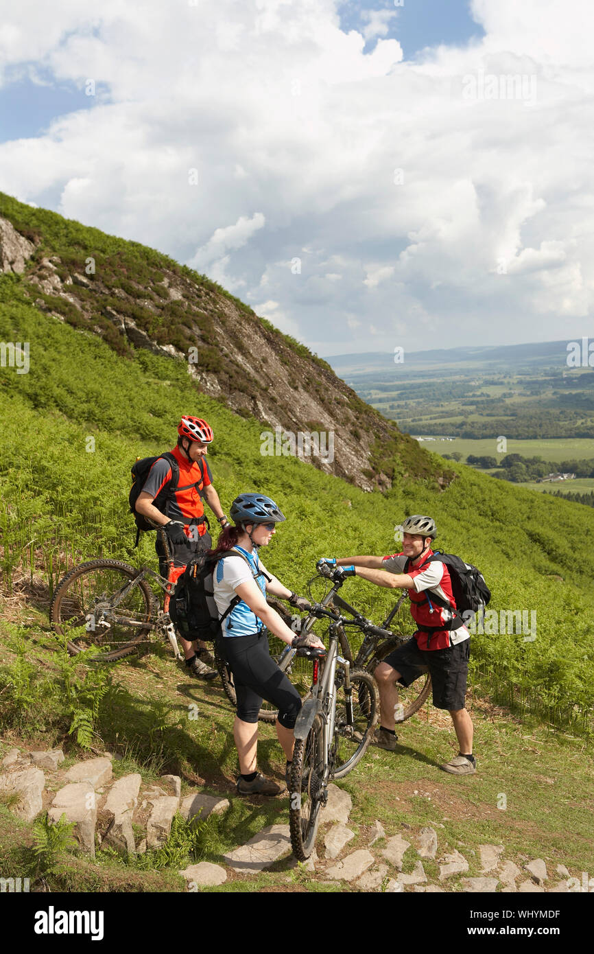 Happy three cyclists with bikes against lush landscape and clouds Stock ...