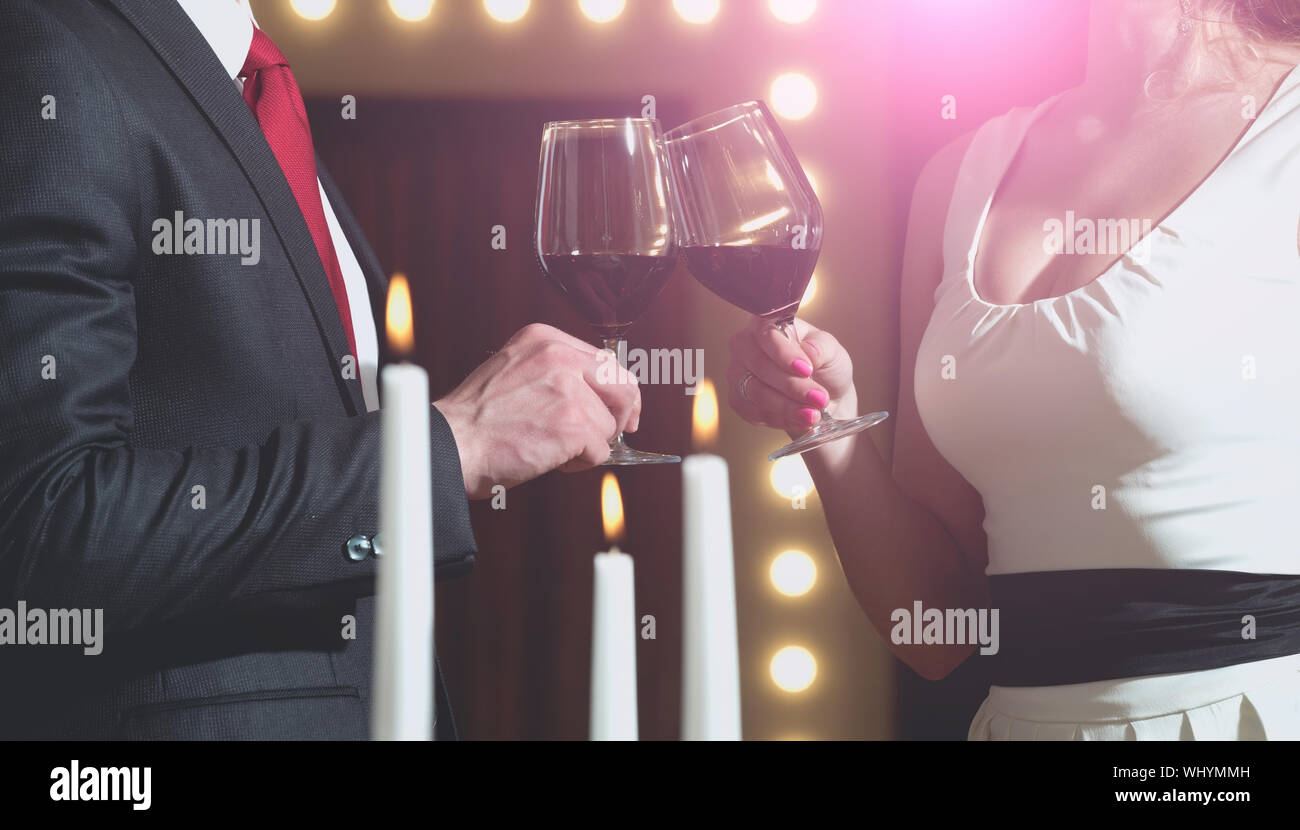 toast of couple clink glasses with red wine at meeting in formal outfit ...