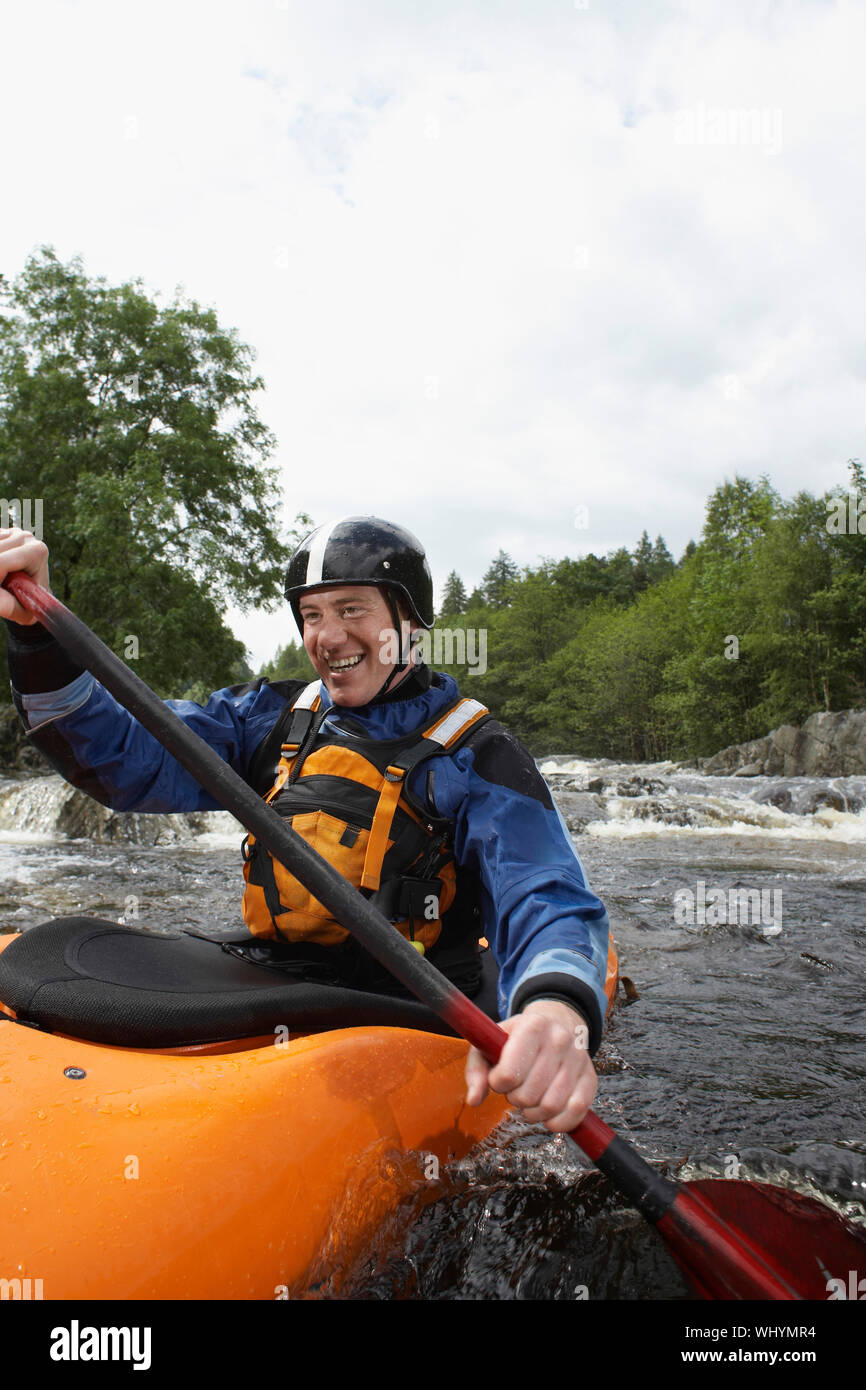 Smiling young man kayaking in the river Stock Photo - Alamy