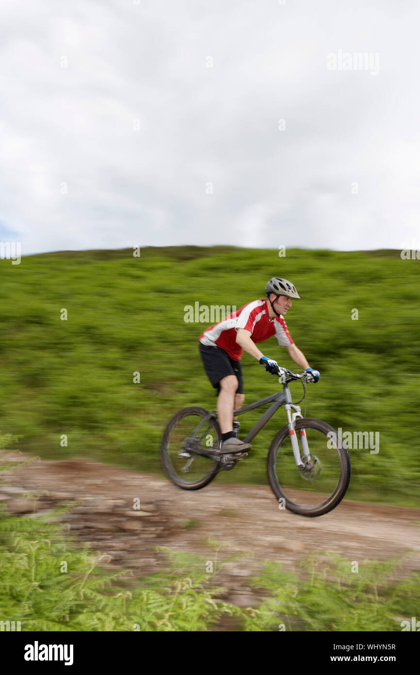 Side view of a male cyclist on countryside track Stock Photo - Alamy