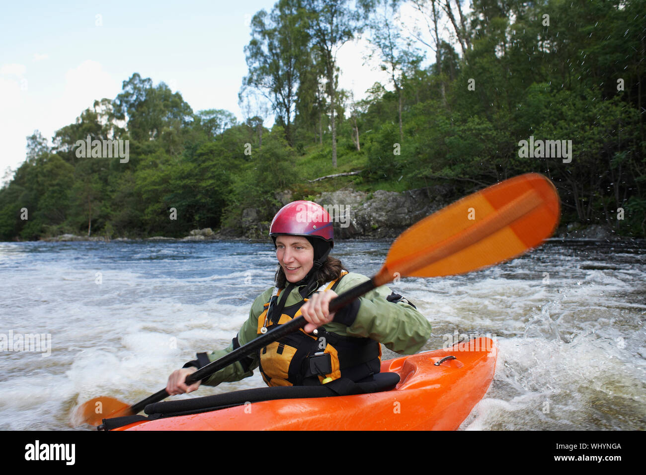 Smiling young woman kayaking in the river Stock Photo - Alamy