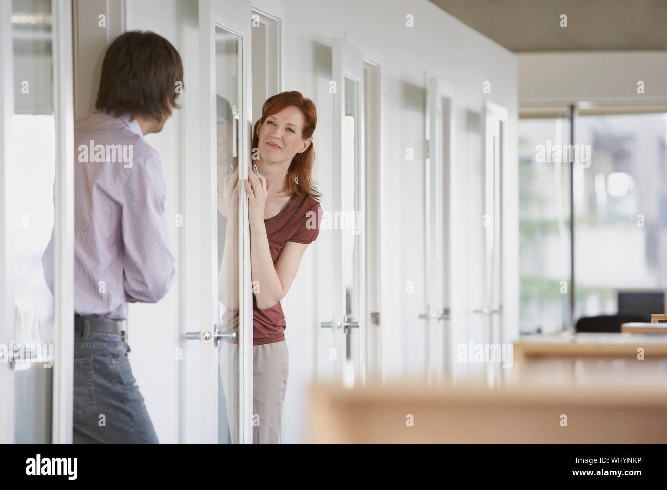 Two colleagues talking through office doors Stock Photo - Alamy