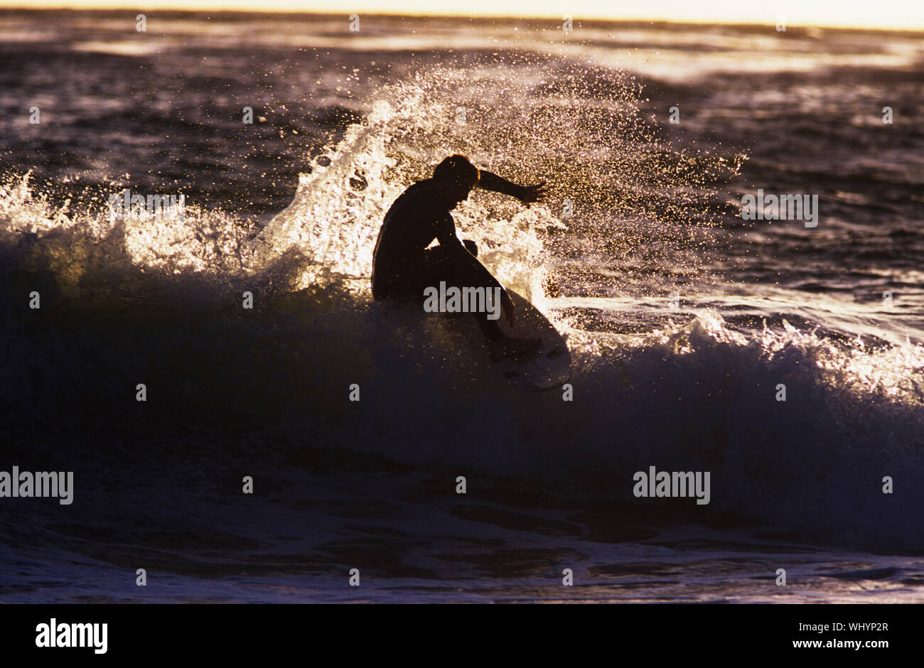 Side view of a silhouette man surfing wave Stock Photo - Alamy