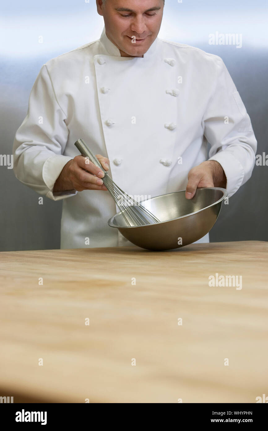 Male chef mixing ingredients with whisk in the kitchen Stock Photo - Alamy
