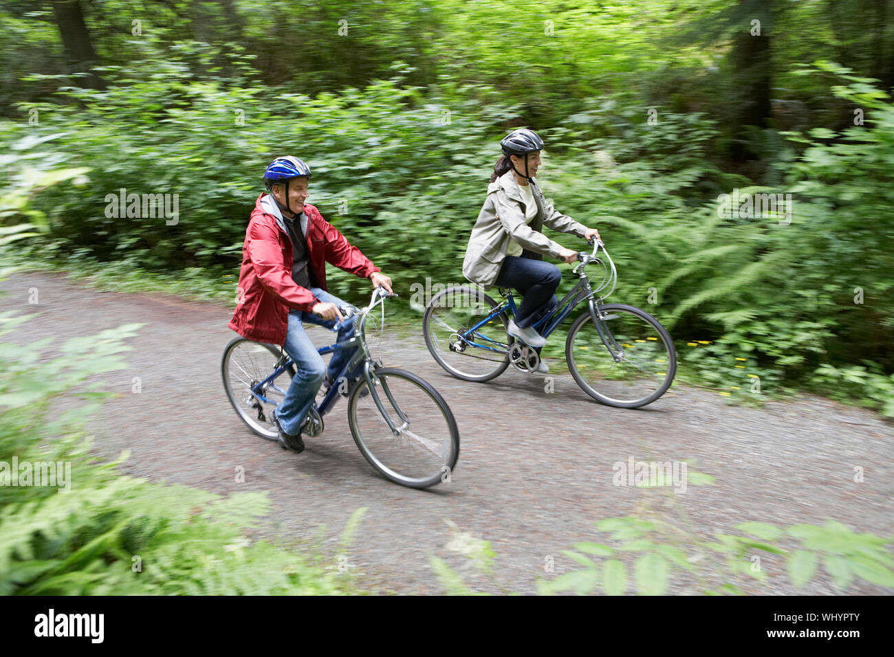 Elevated view of two people biking on forest road Stock Photo - Alamy