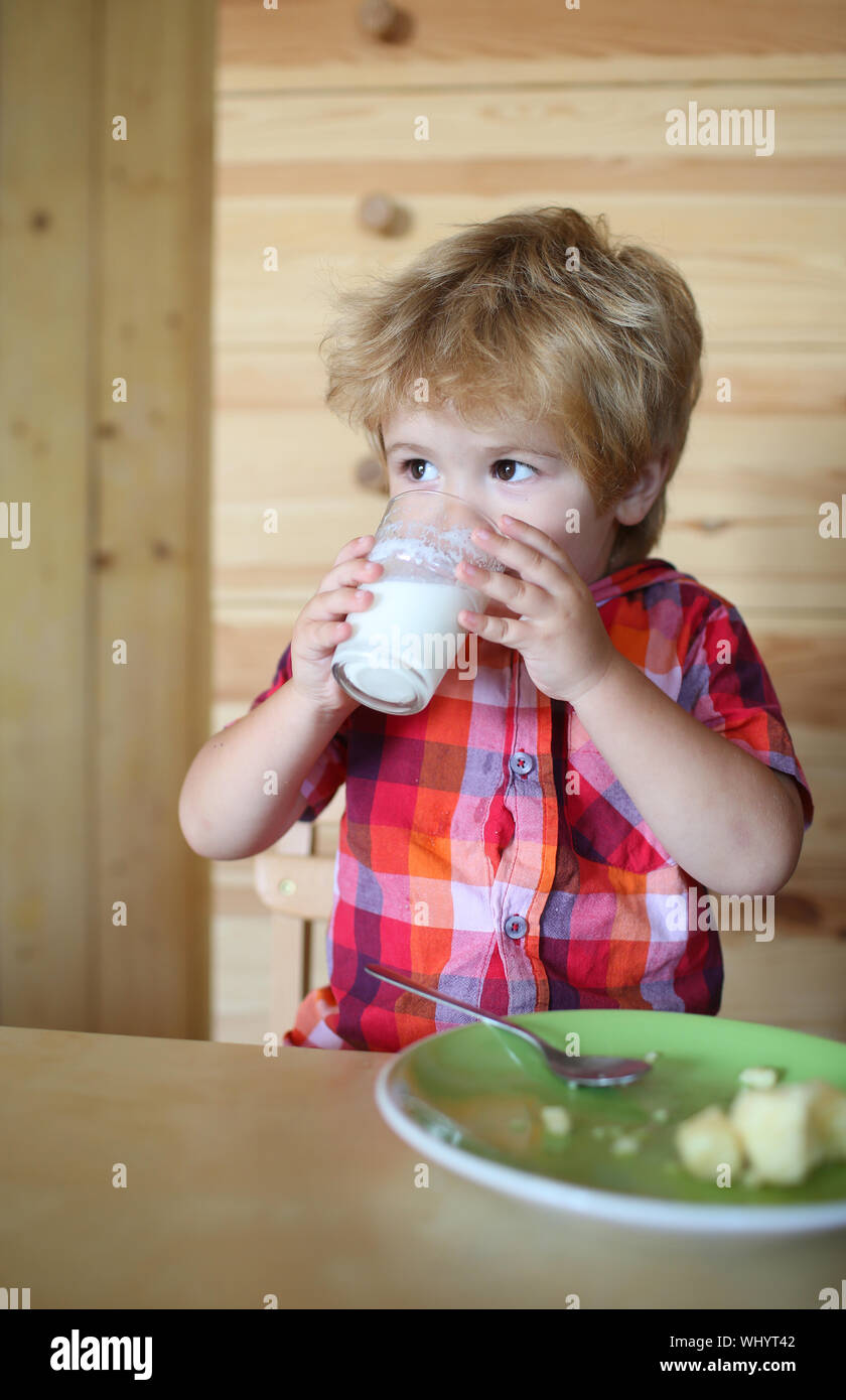 Healthy food and vitamin. Small boy child eat banana and drink milk ...