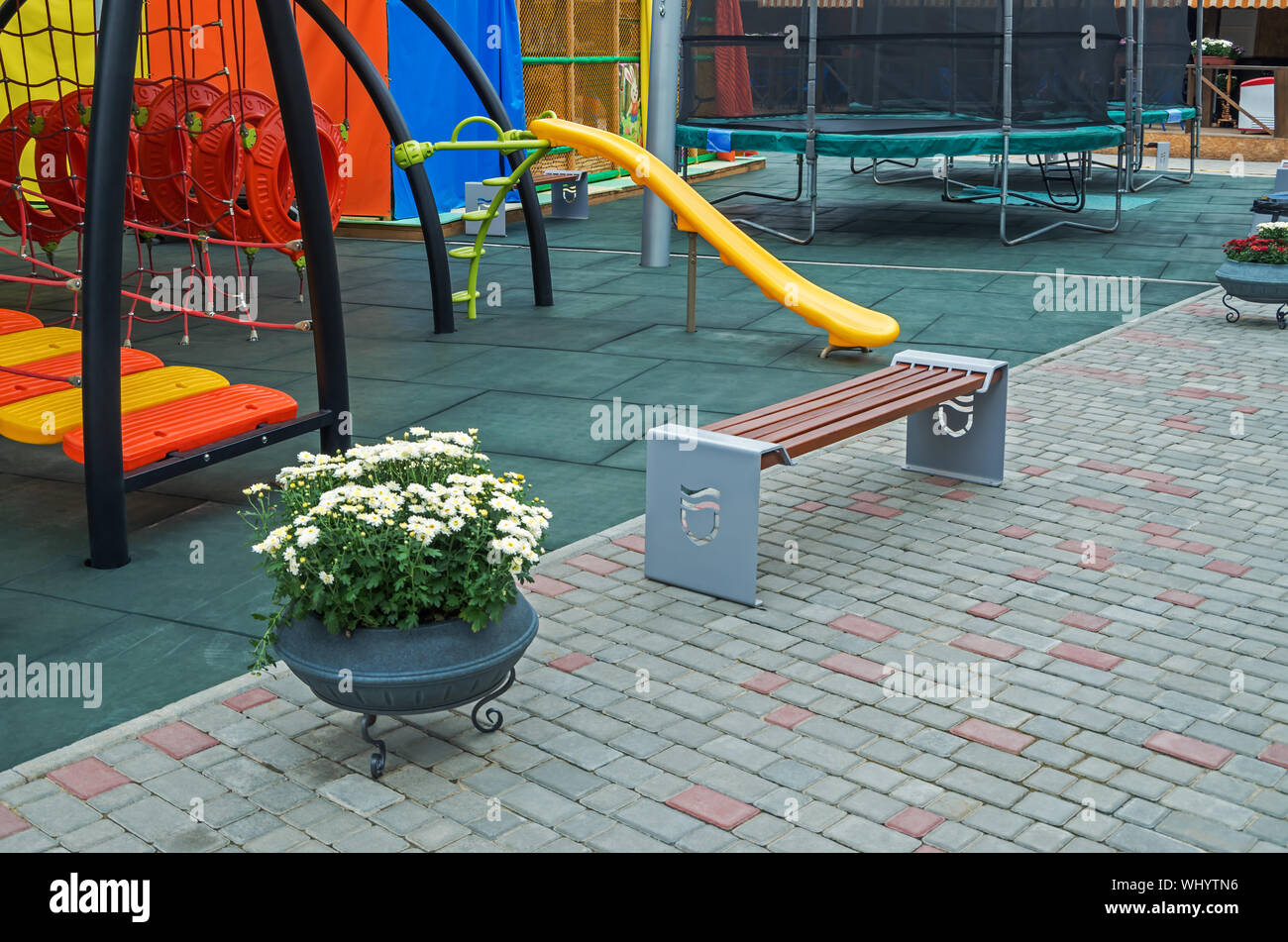 Recreation area with bench and flower pots at playground in the city ...