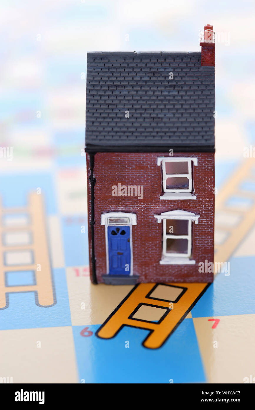 Plastic house on game board Stock Photo - Alamy
