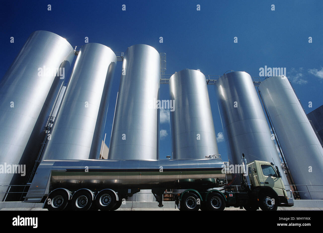 Milk transport truck parked alongside storage tanks Stock Photo - Alamy