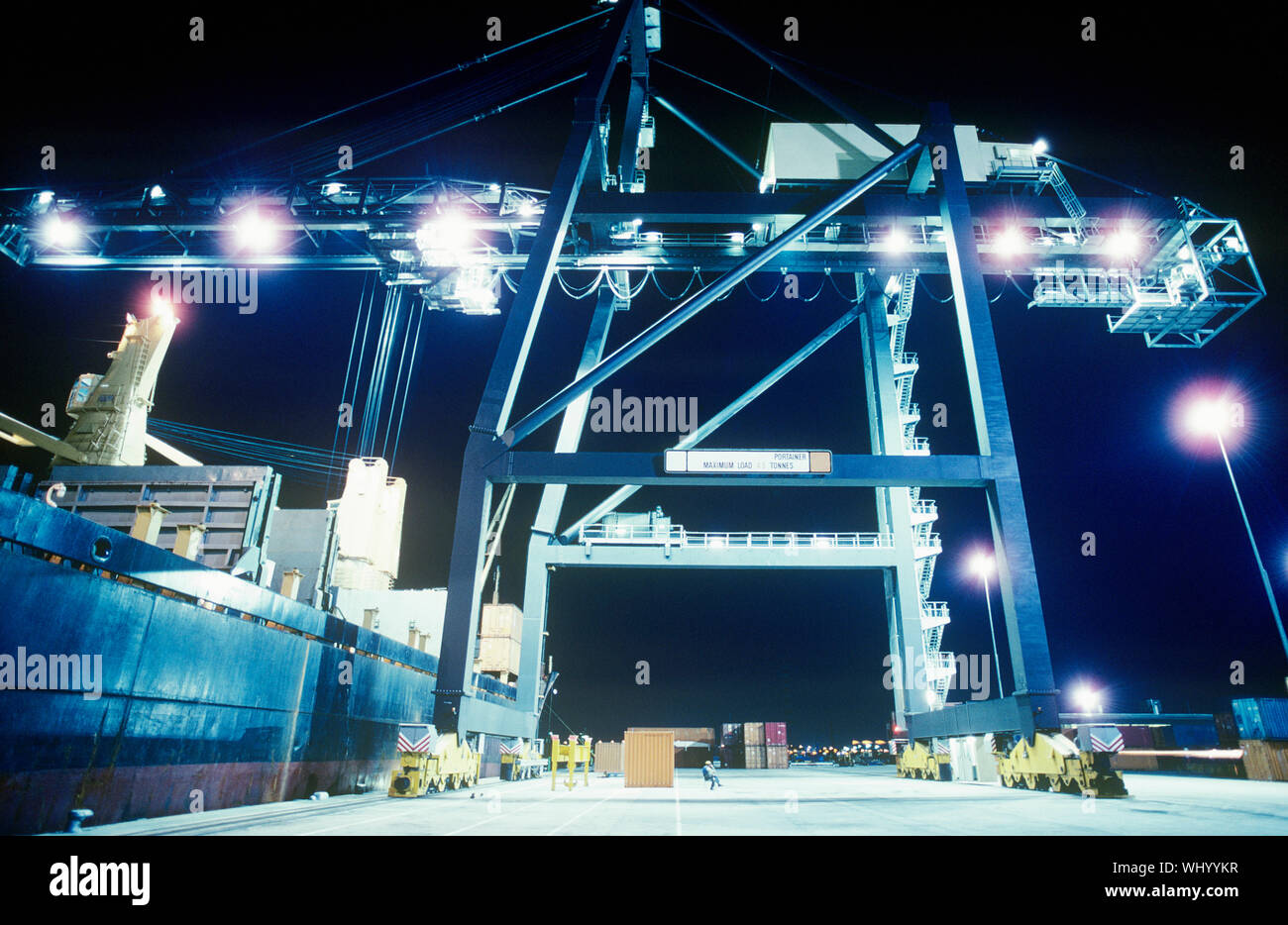Crane loading container ship at night Stock Photo - Alamy