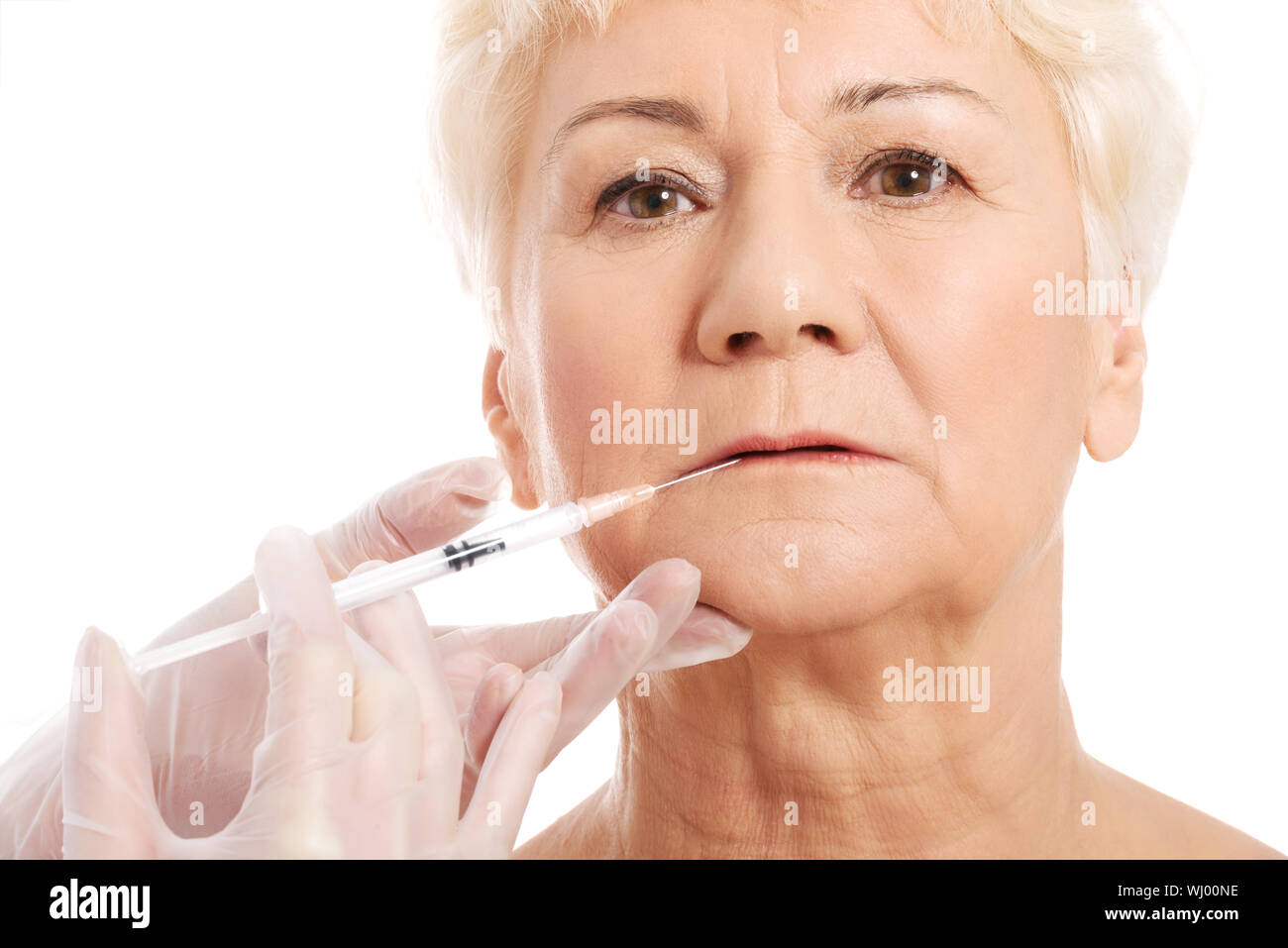 An old woman having a injection- beauty concept. Isolated on white ...