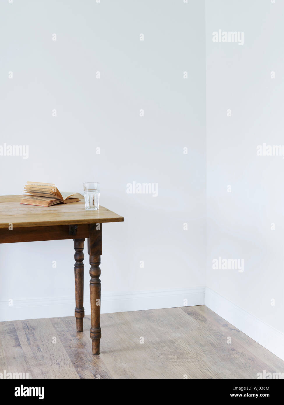 Glass of water and open book in room Stock Photo - Alamy