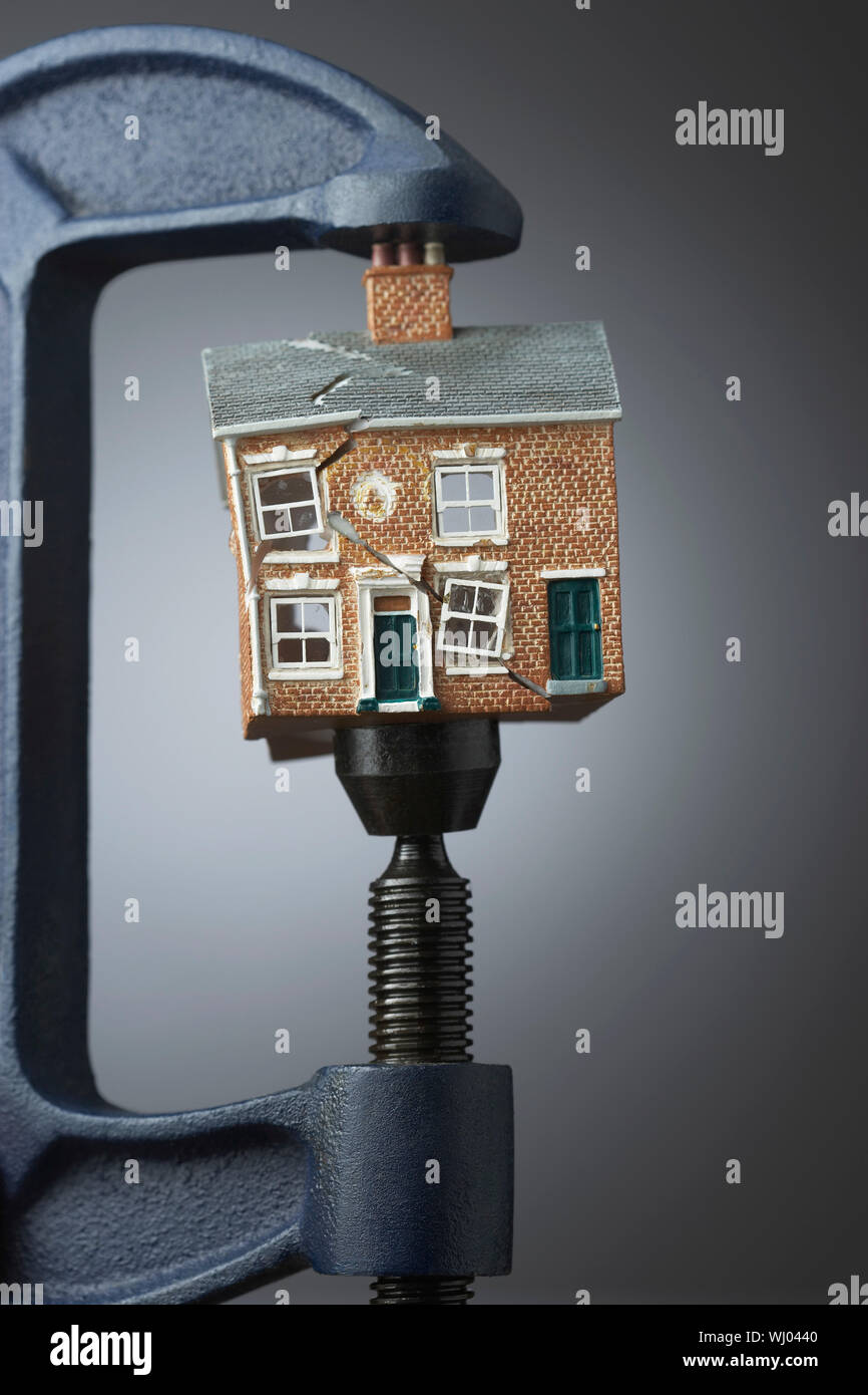 Vice gripping small model house Stock Photo - Alamy