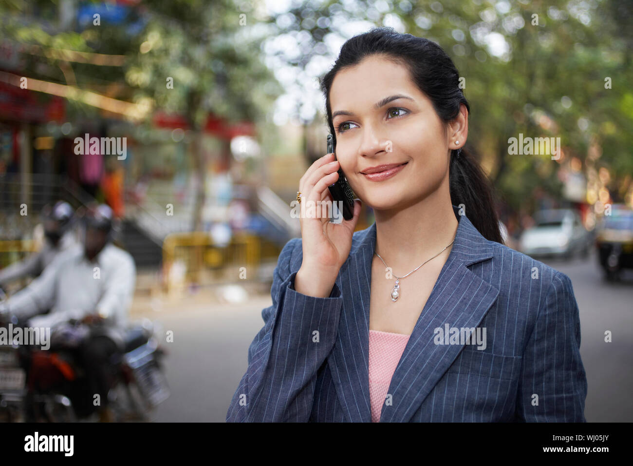 Beautiful young businesswoman using cell phone on city street Stock ...
