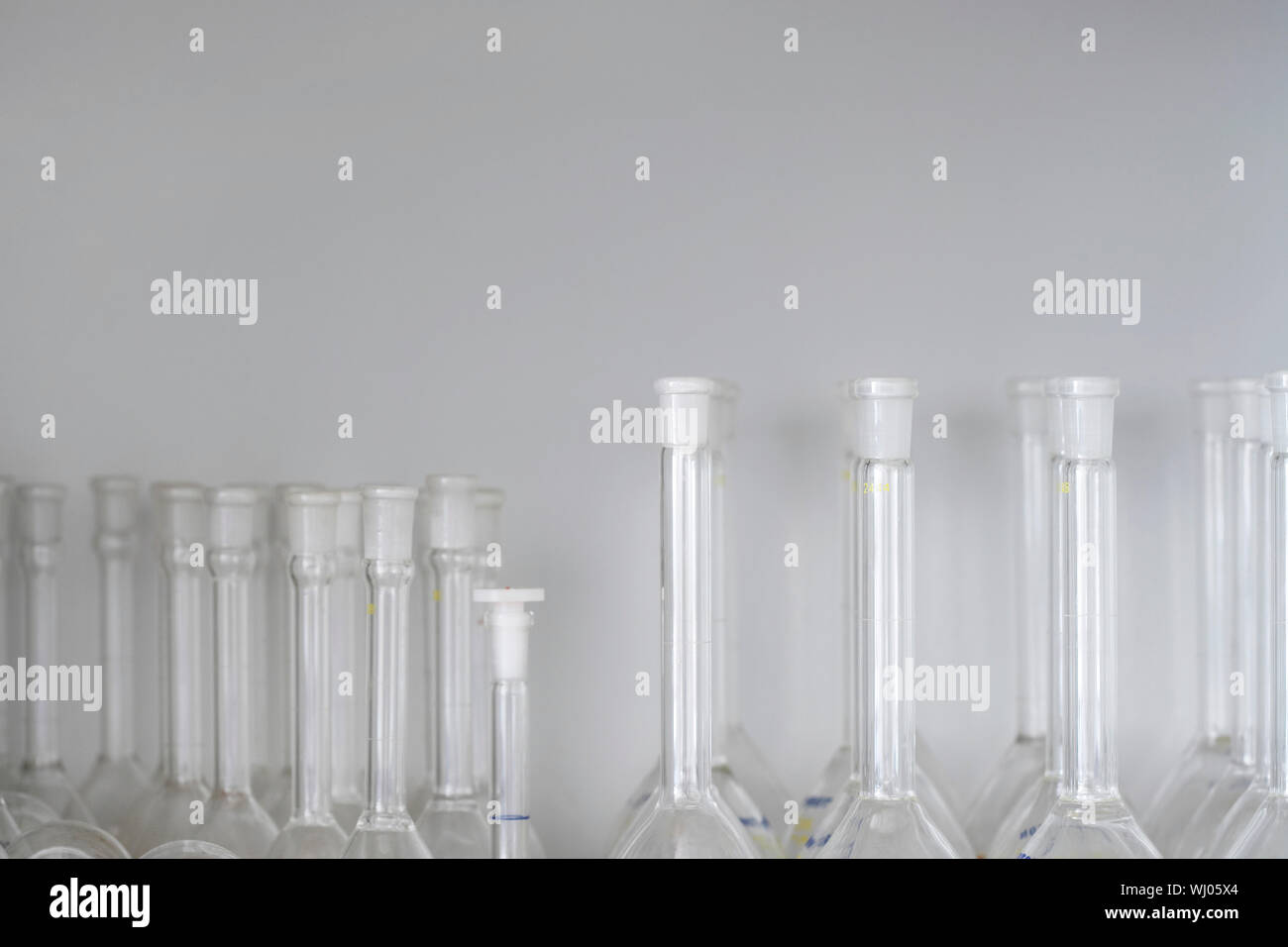 Scientific flasks displayed against white wall in laboratory Stock ...
