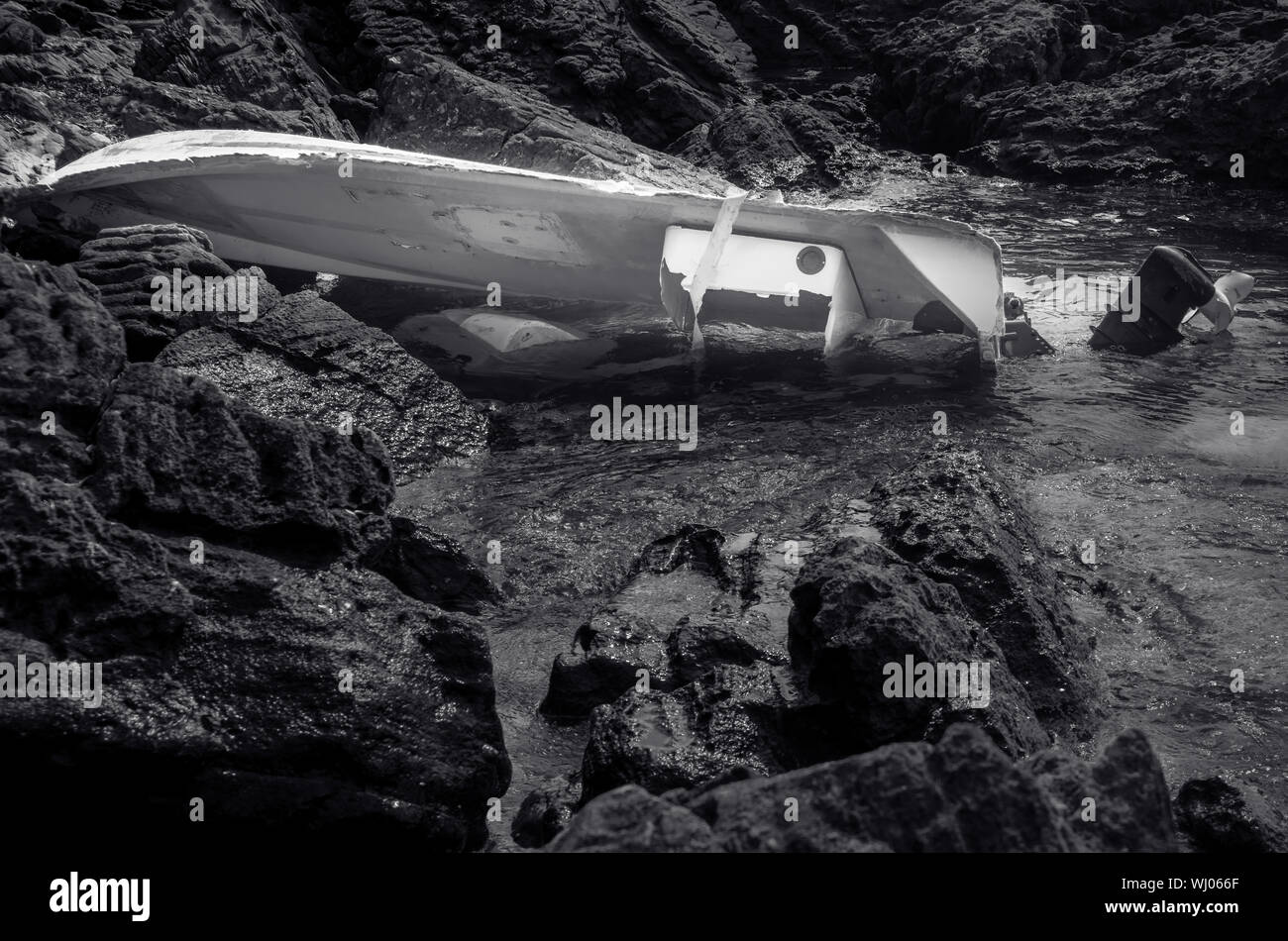 Broken Boat Against Rocks At Seaside Stock Photo - Alamy