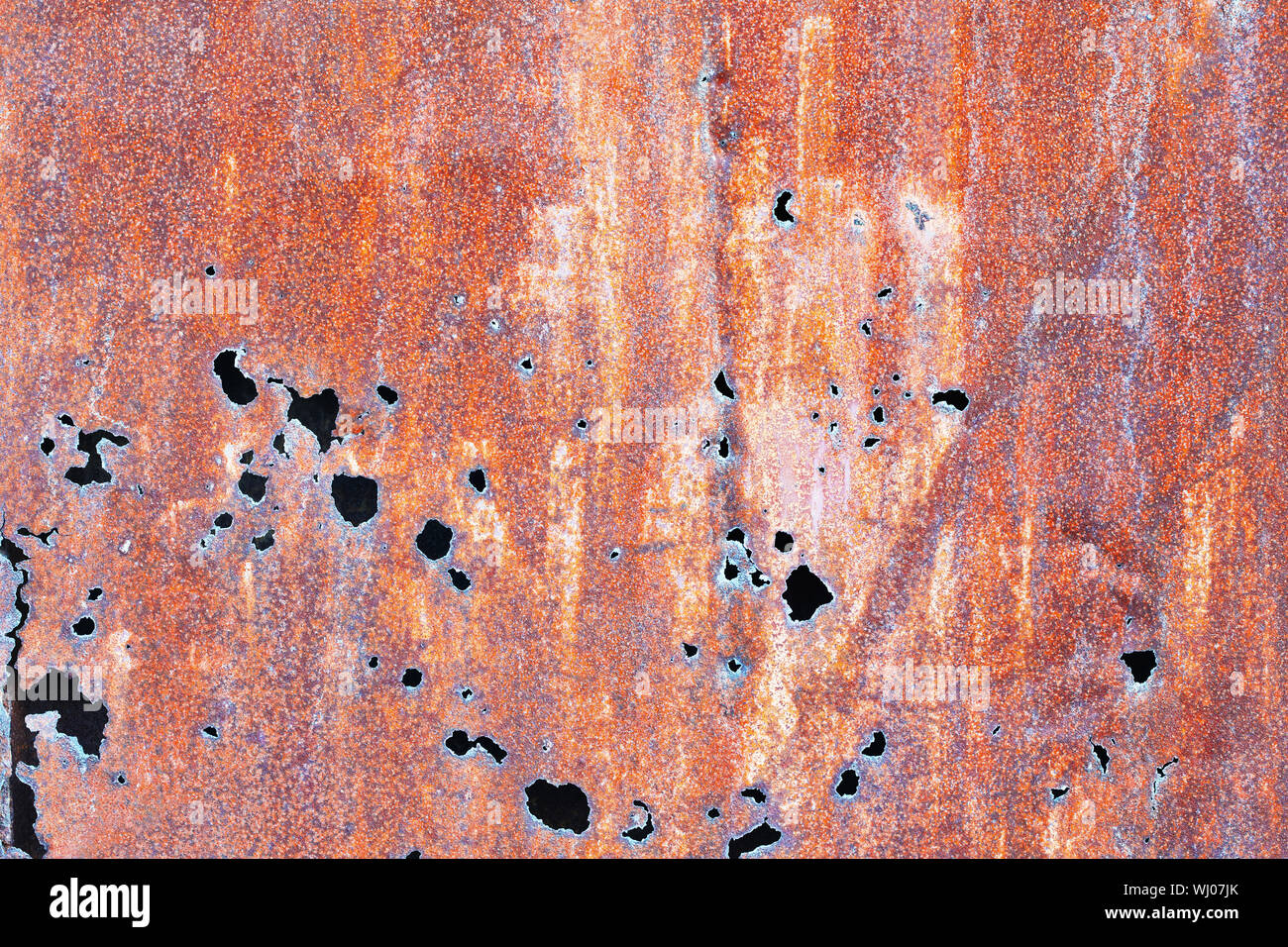 A rusty steel sheet with holes worn-out Stock Photo - Alamy