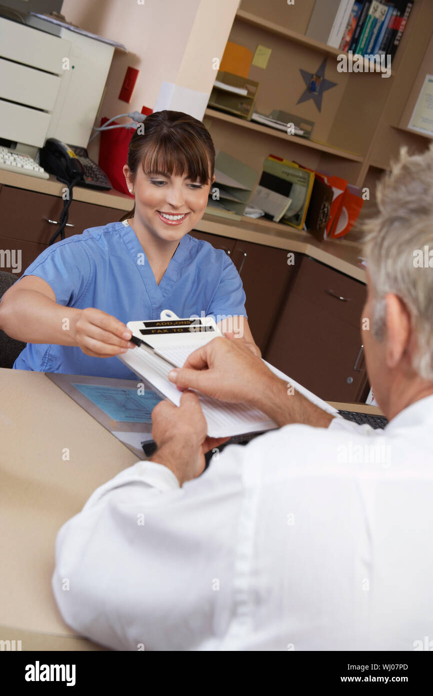 Nurse and doctor doing paperwork in doctor's office Stock Photo - Alamy