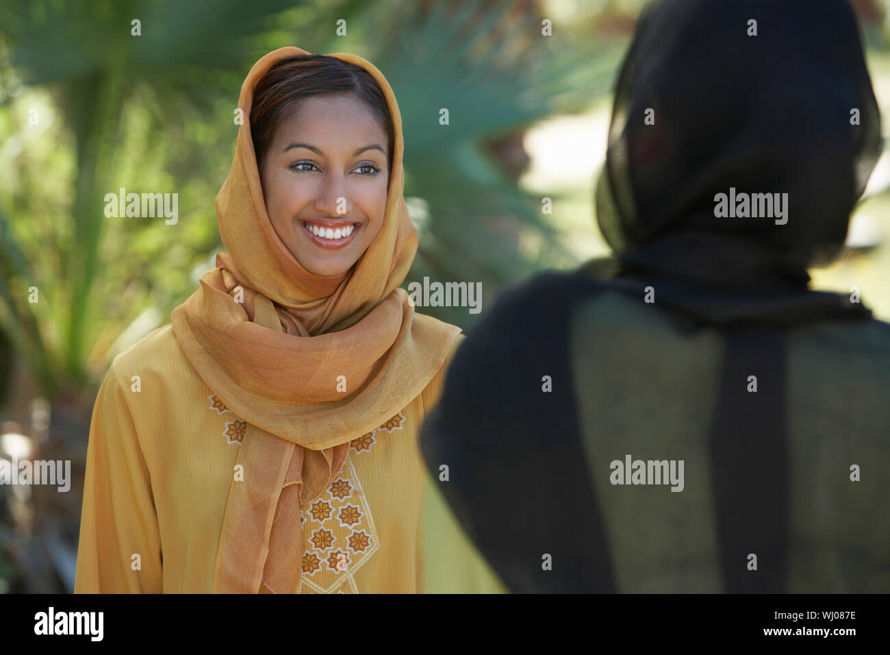 Two muslim woman in traditional clothing talking Stock Photo - Alamy