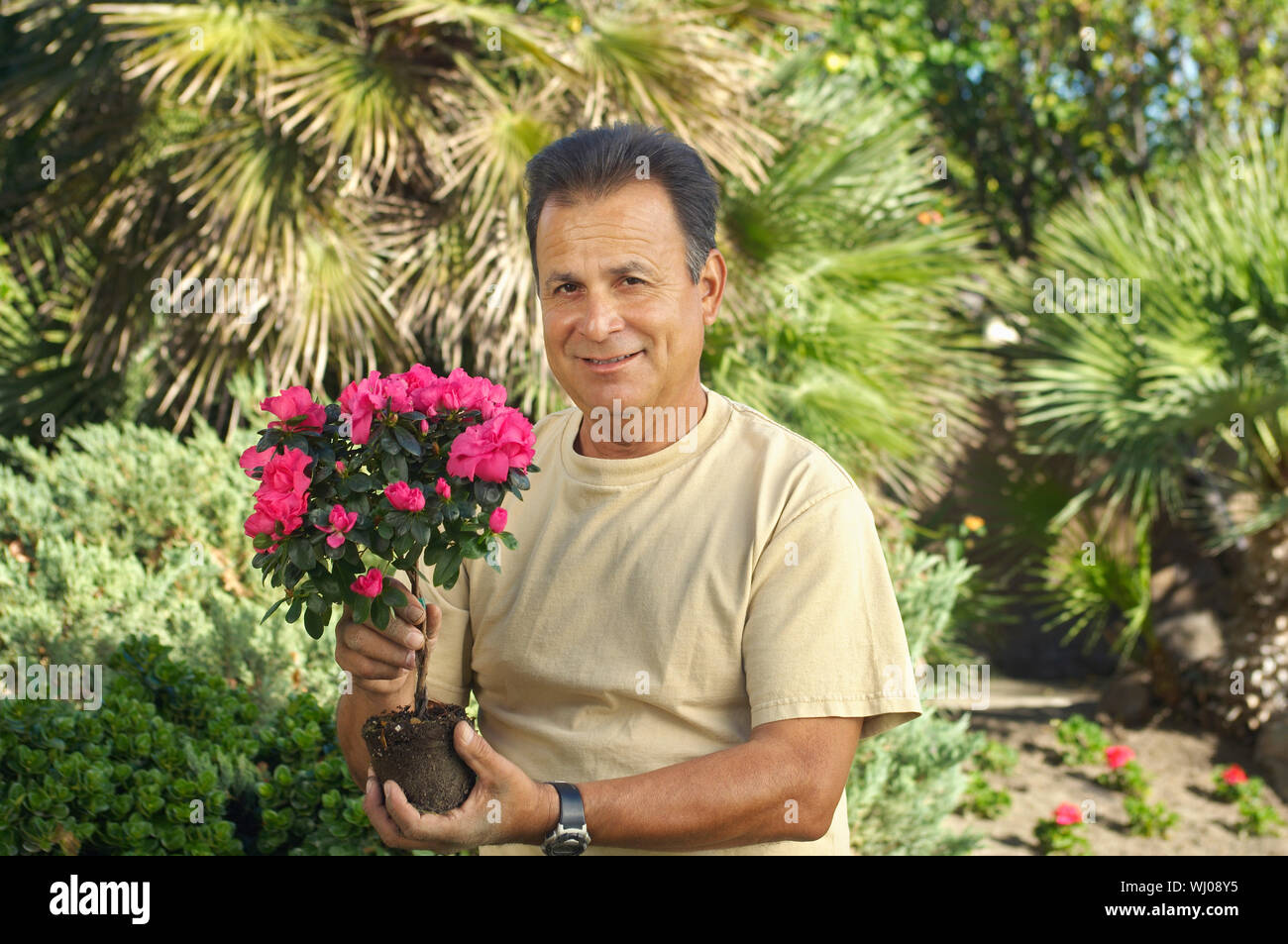 Portrait of man with flowers in garden Stock Photo - Alamy