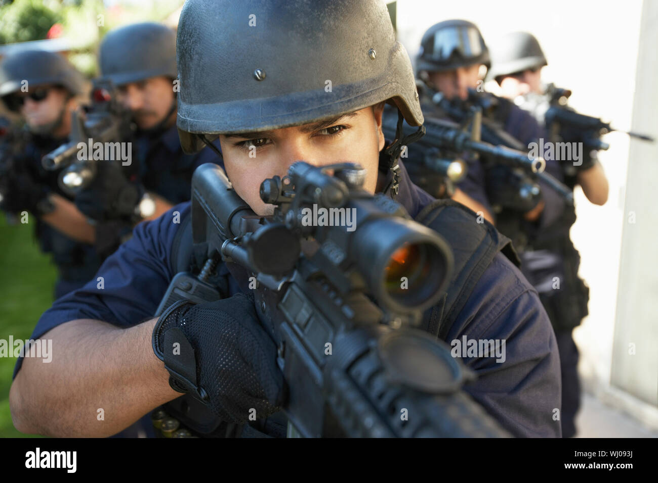 Multi ethnic group of police officers aiming with guns Stock Photo - Alamy