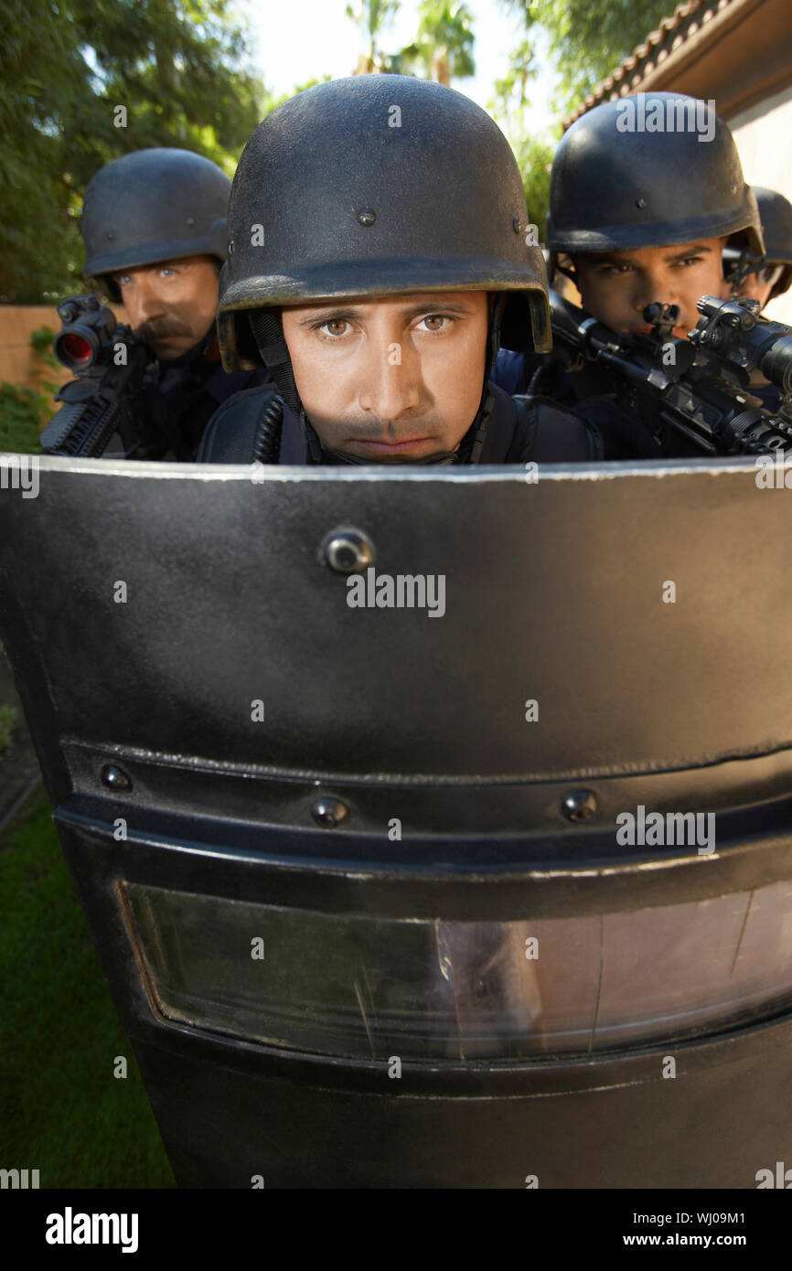 Swat officers standing behind shield Stock Photo - Alamy