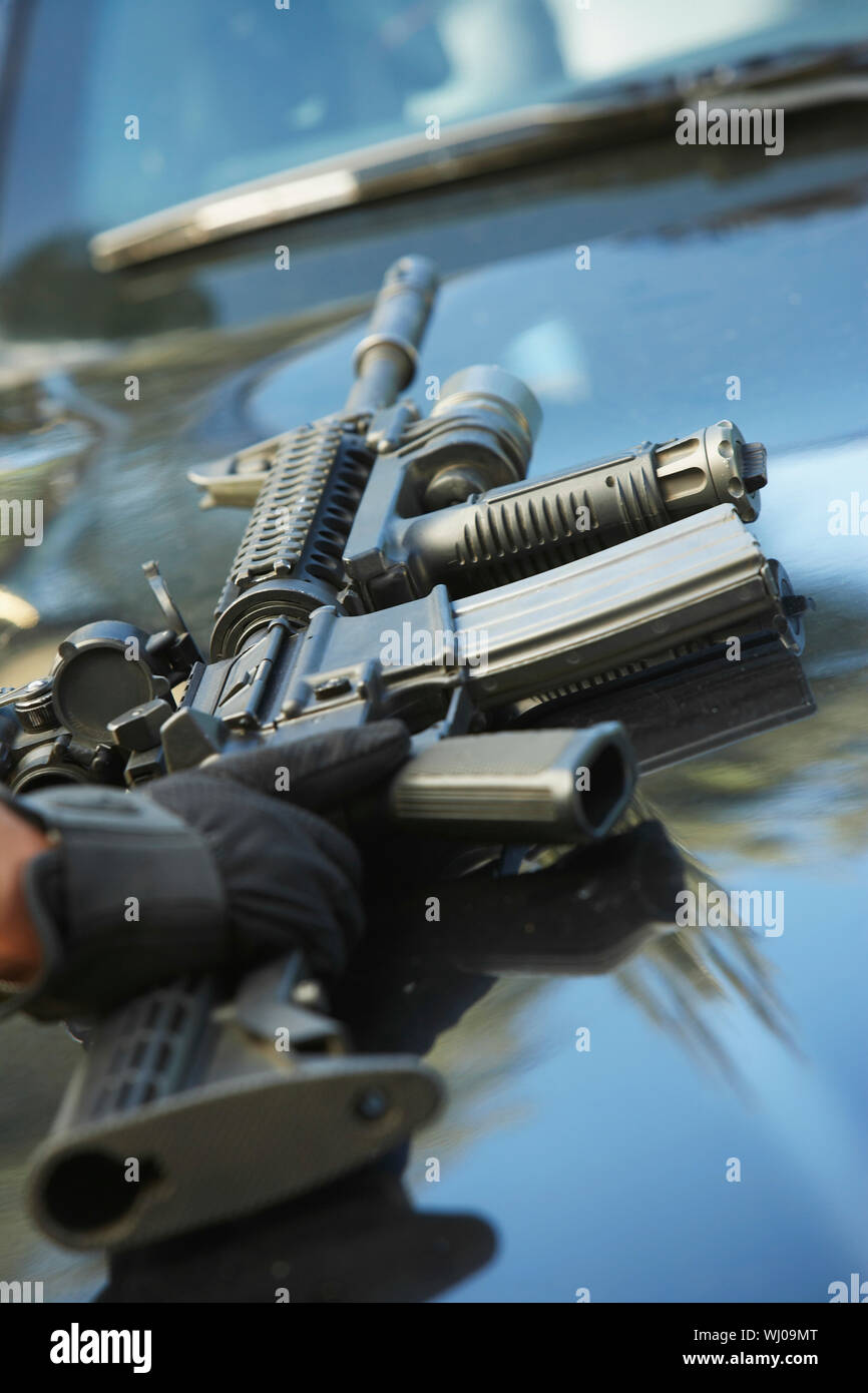 Closeup of policeman's hand picking up gun from car hood Stock Photo ...