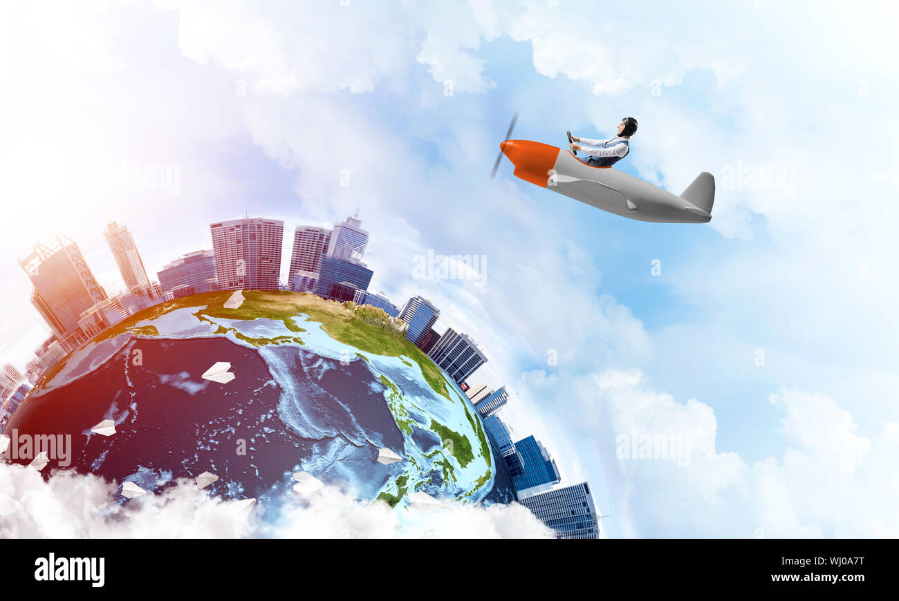 Man in aviator hat with goggles driving propeller plane. Earth globe ...