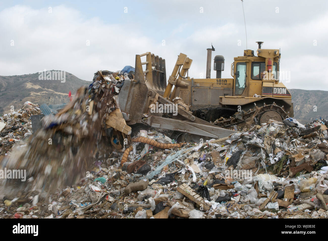 Digger moving waste at landfill site Stock Photo - Alamy