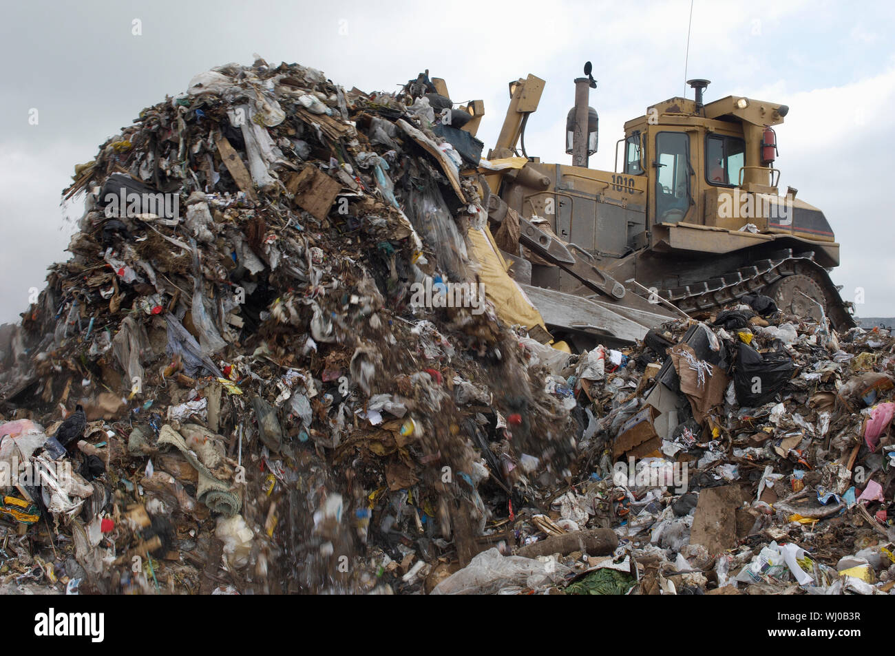 Digger moving waste at landfill site Stock Photo - Alamy