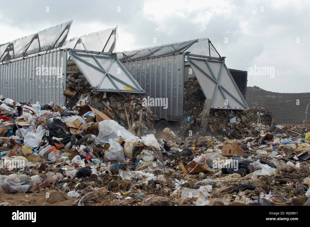 Trucks dumping waste at landfill site Stock Photo - Alamy