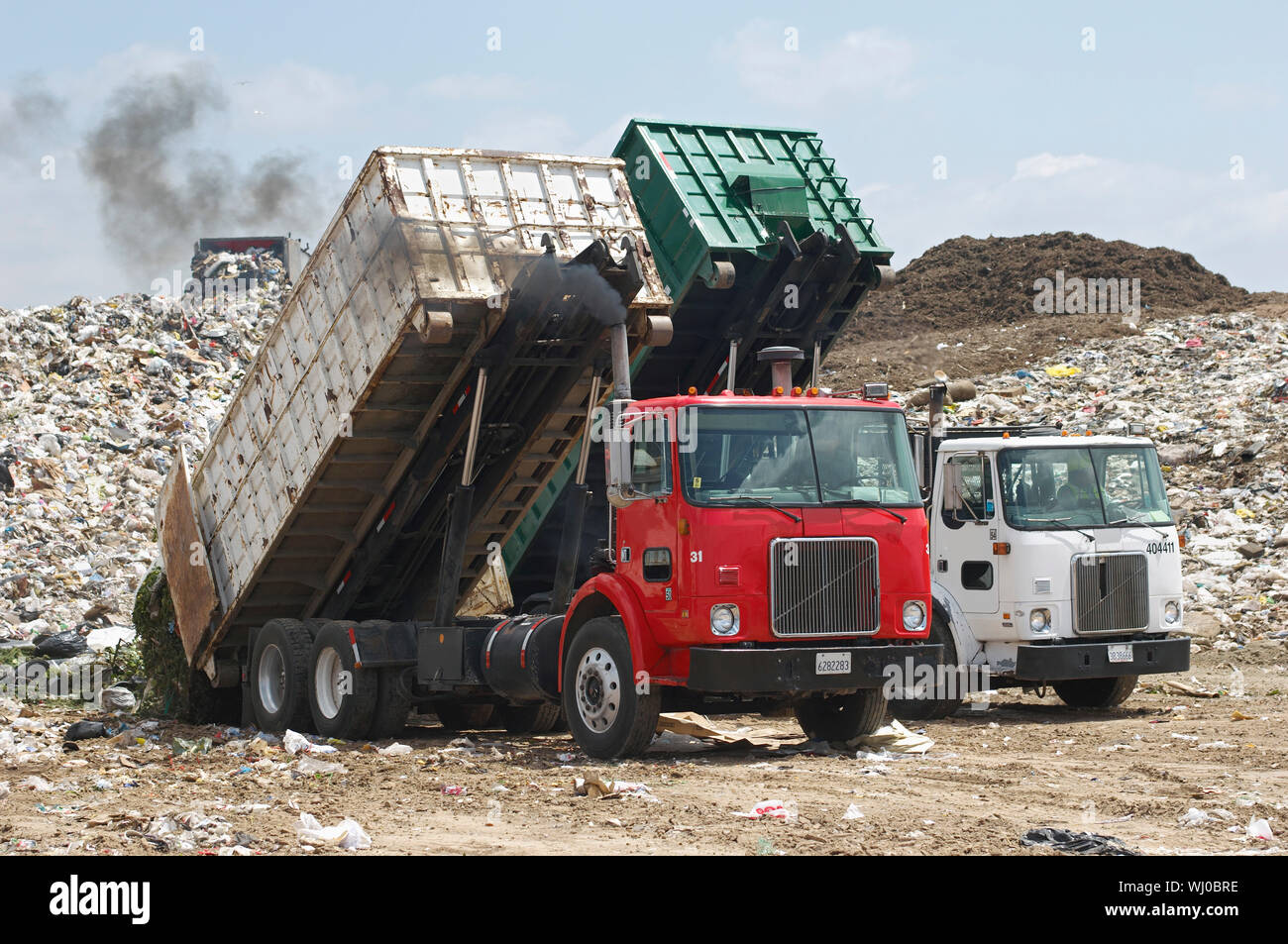 Trucks dumping waste at landfill site Stock Photo - Alamy