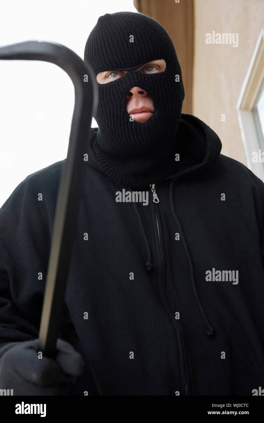 Man wearing balaclava and holding crowbar Stock Photo - Alamy
