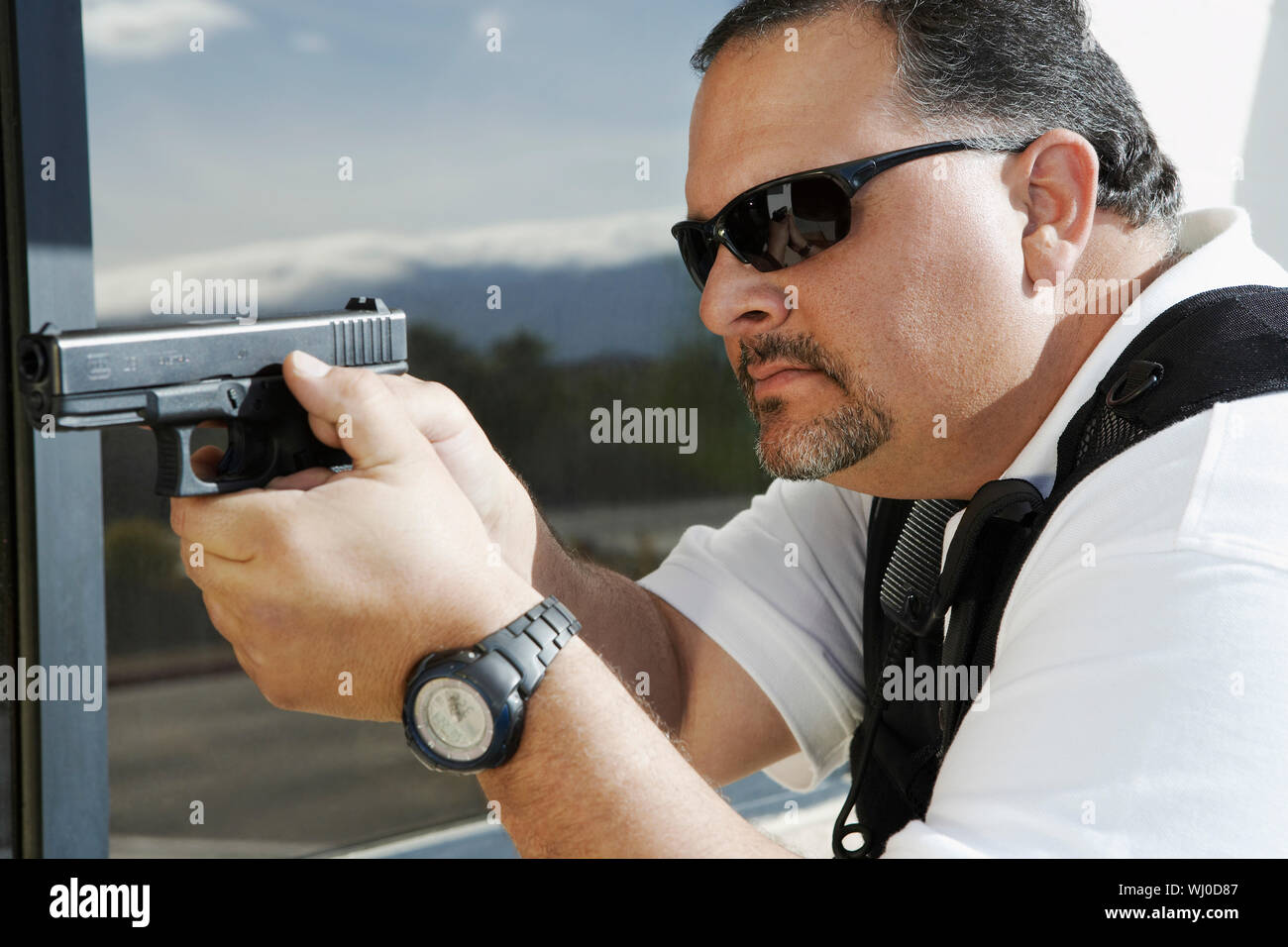 Security guard aiming with gun outdoors Stock Photo - Alamy
