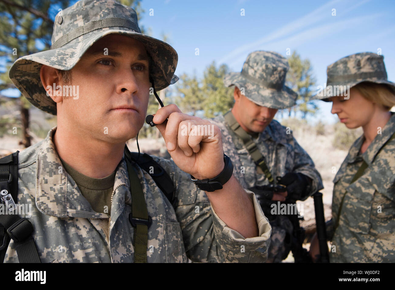 Soldiers in field, focus on soldier in foreground Stock Photo - Alamy