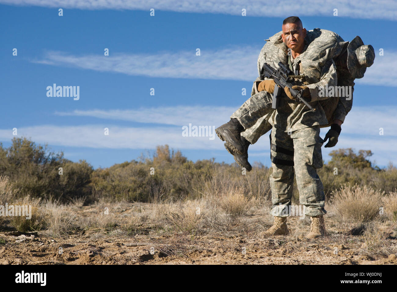 US Army soldier carrying wounded friend Stock Photo - Alamy