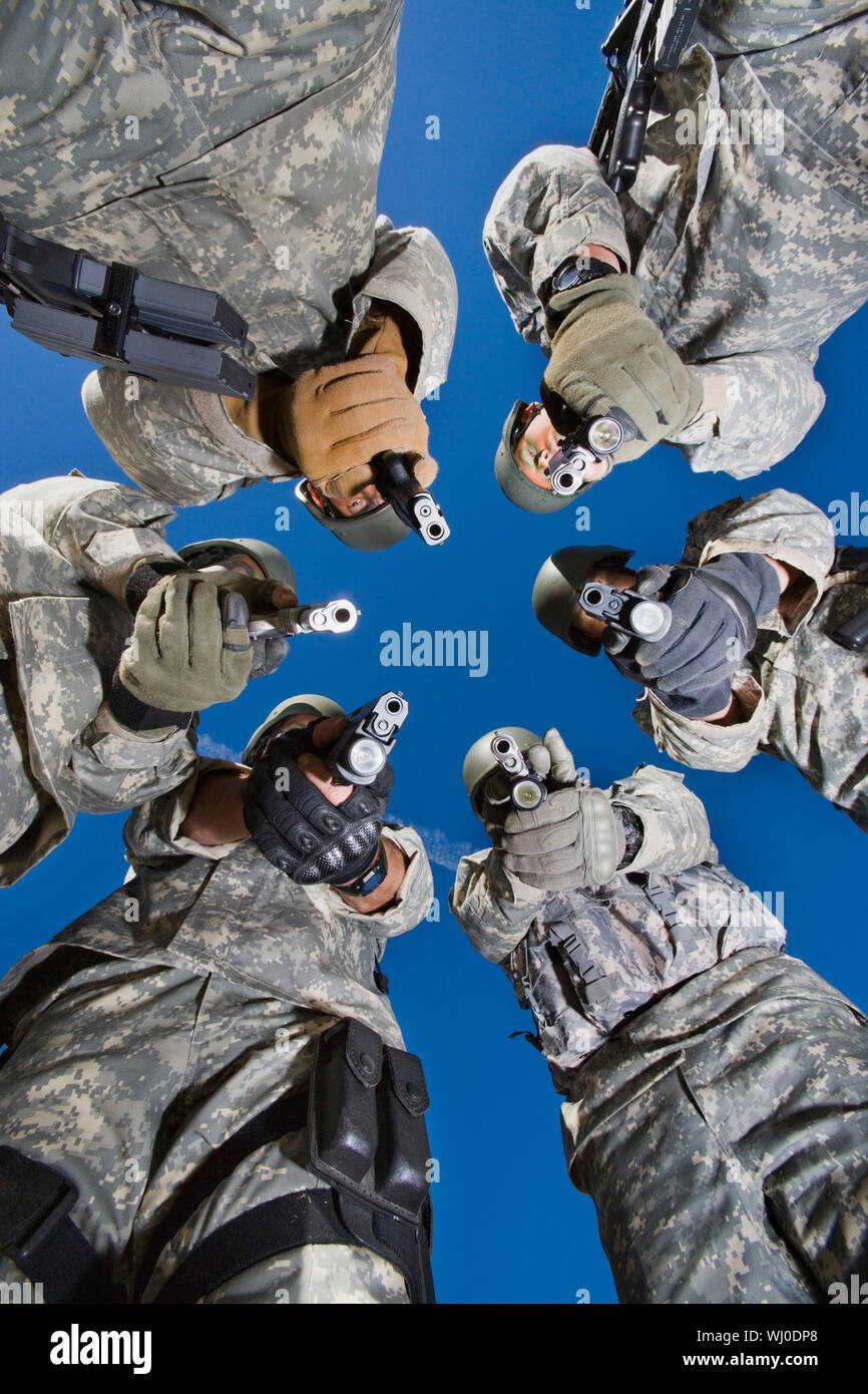 Low angle portrait of soldiers standing in circle, aiming Stock Photo ...
