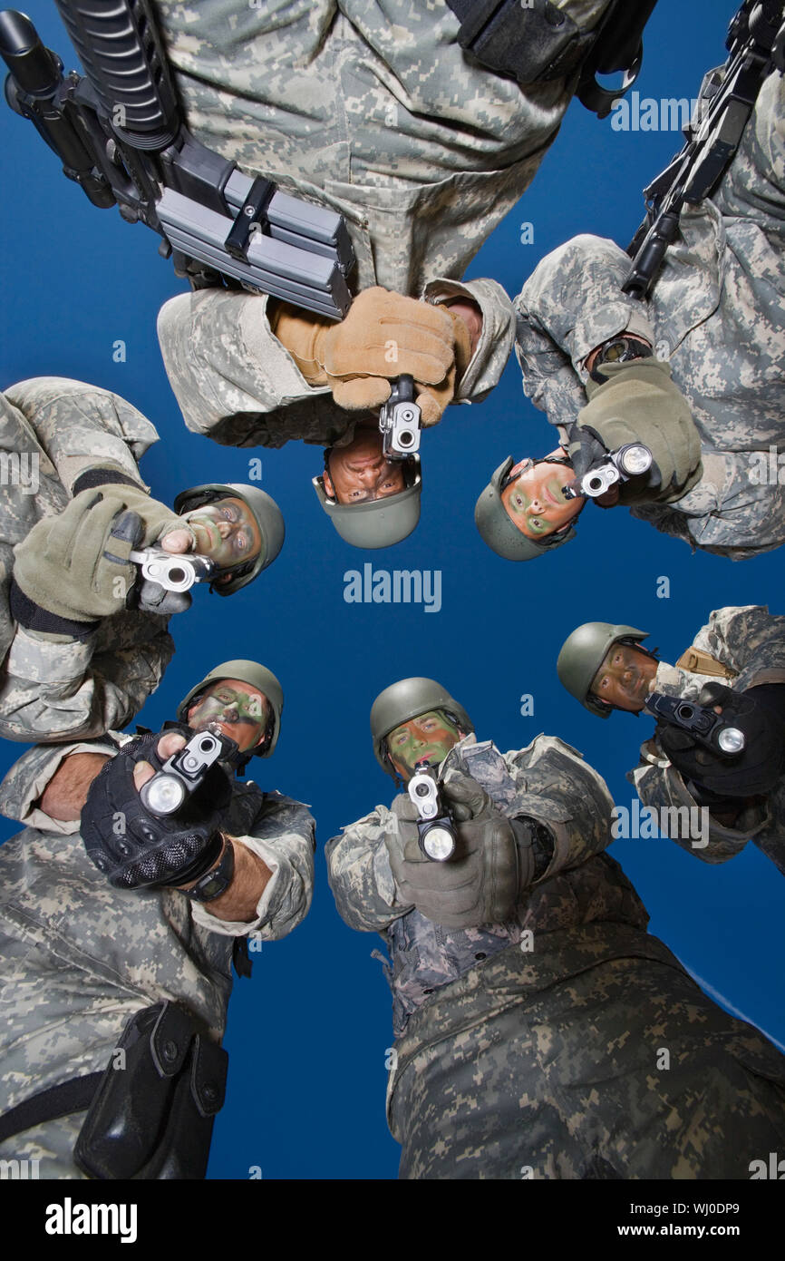 Low angle portrait of soldiers standing in circle, aiming Stock Photo ...