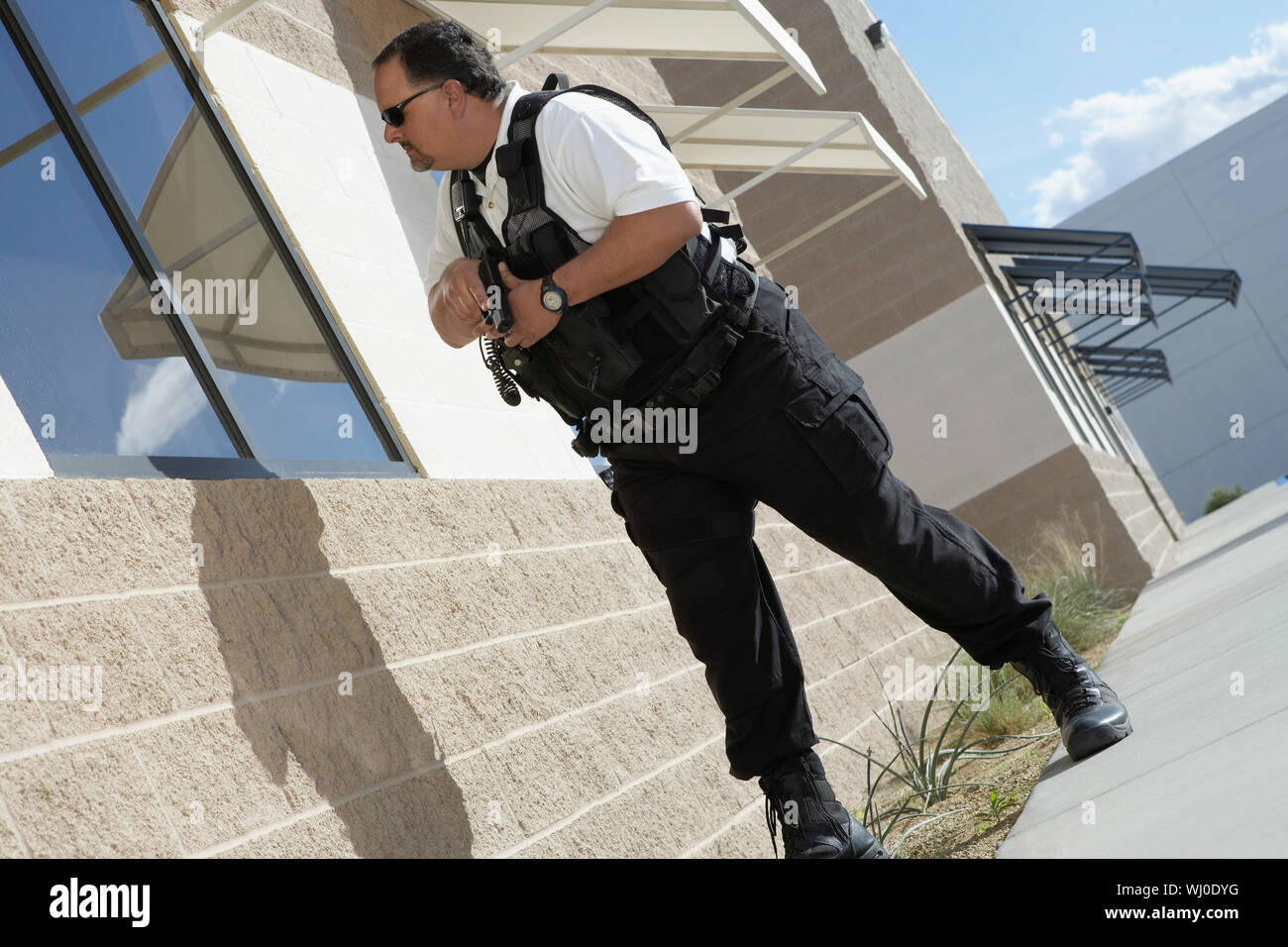 Security guard with gun patrolling Stock Photo - Alamy